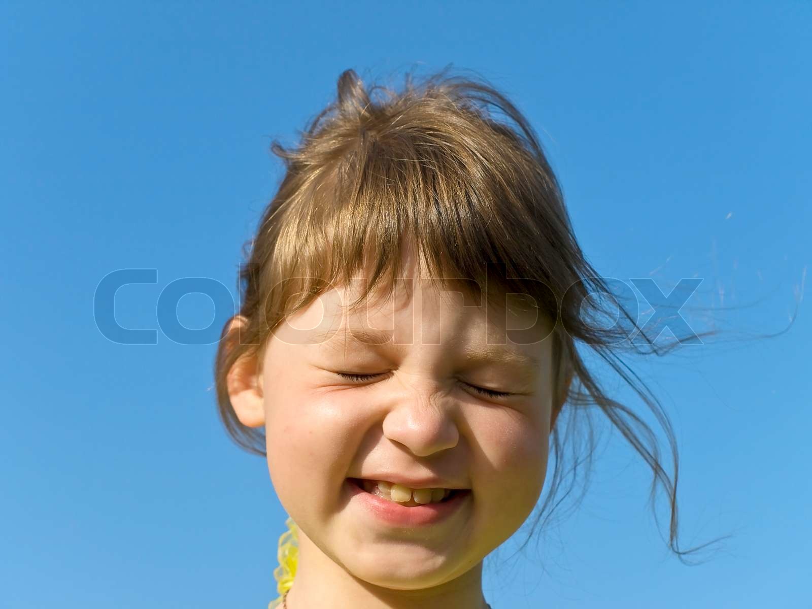 Child shut eyes in emotions against the blue sky | Stock image | Colourbox