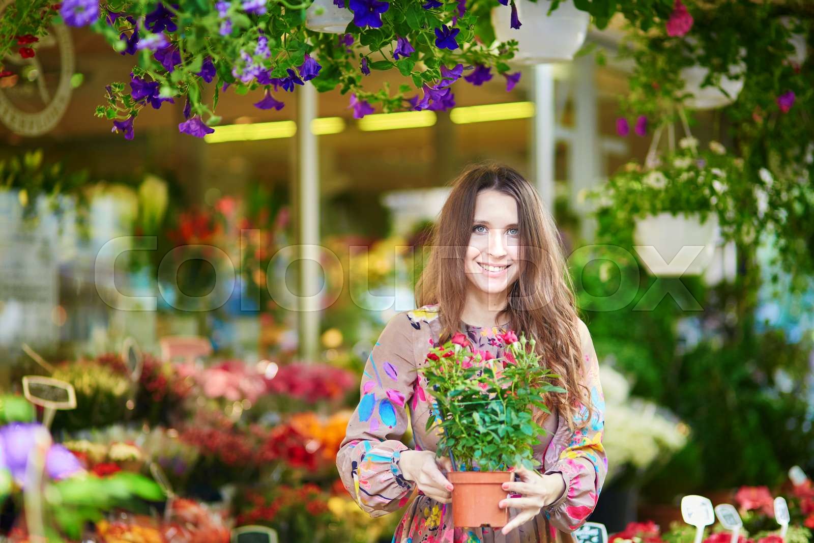 Beautiful customer selecting fresh flowers in Parisian flower shop ...