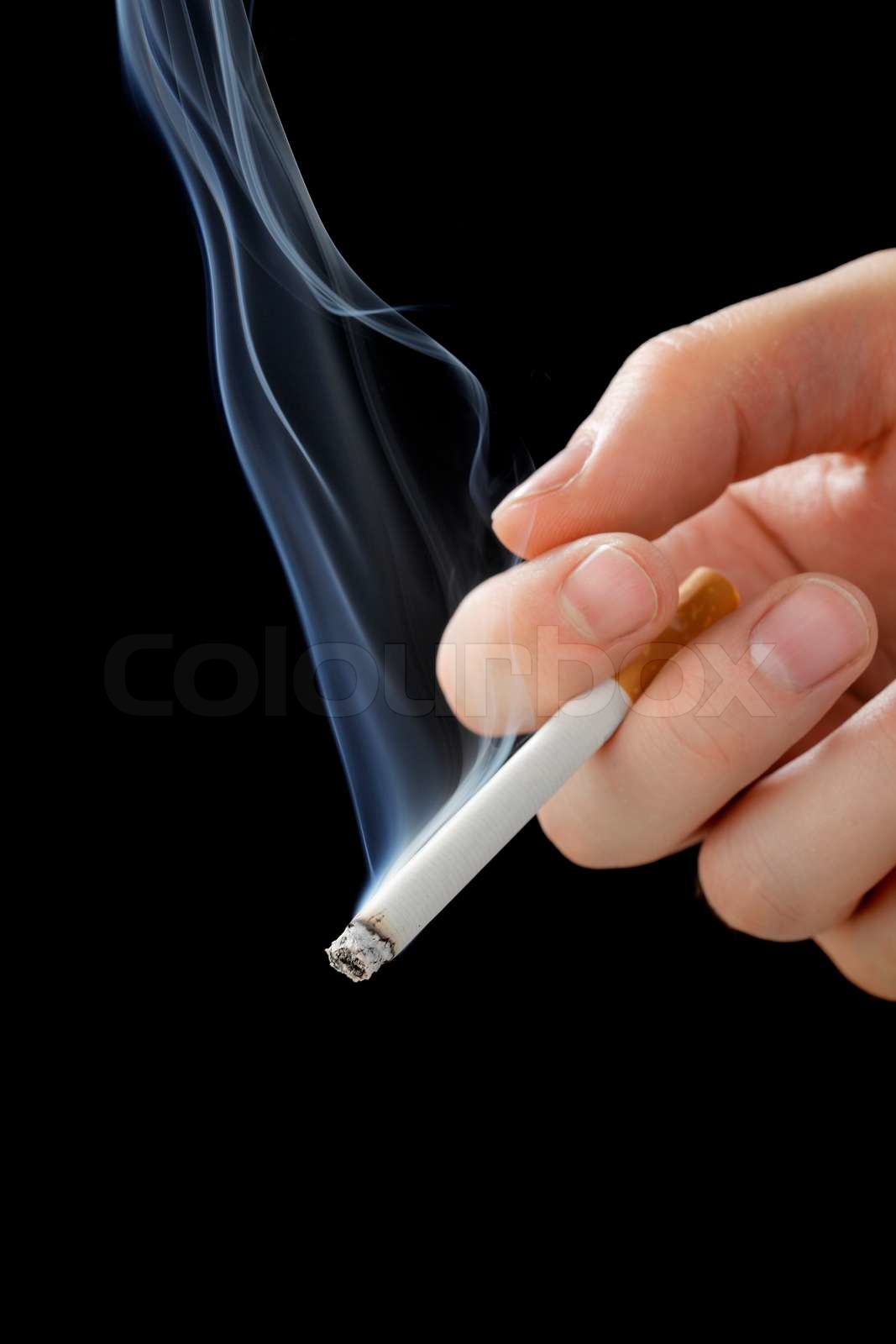 A Hand holding a smoking cigarette | Stock image | Colourbox