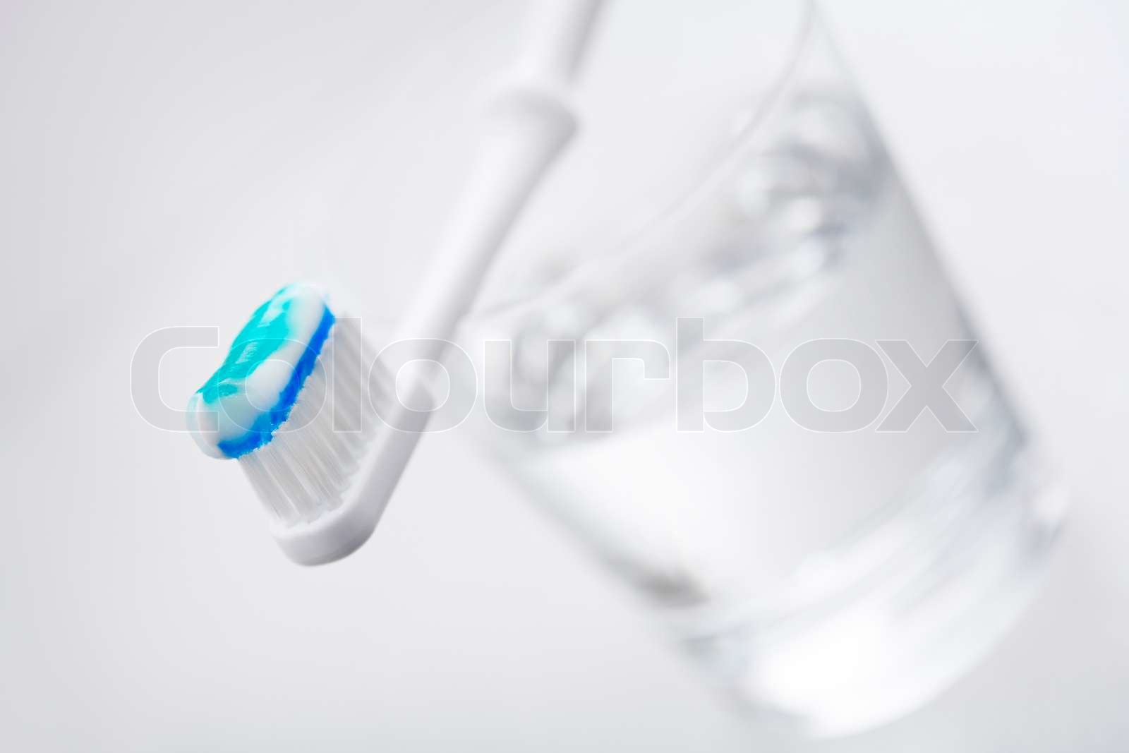 Toothbrush with some toothpaste and a glass of water | Stock image ...