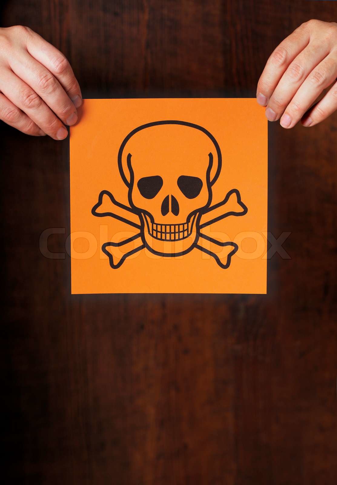 Man holding the symbol for poison in his hands. | Stock image | Colourbox