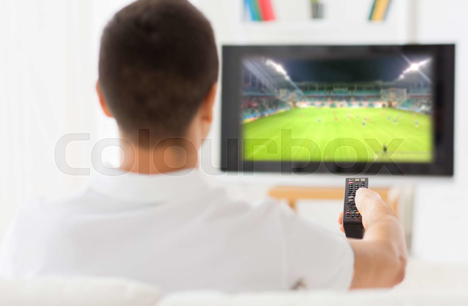 man watching football game on tv at home from back | Stock image ...