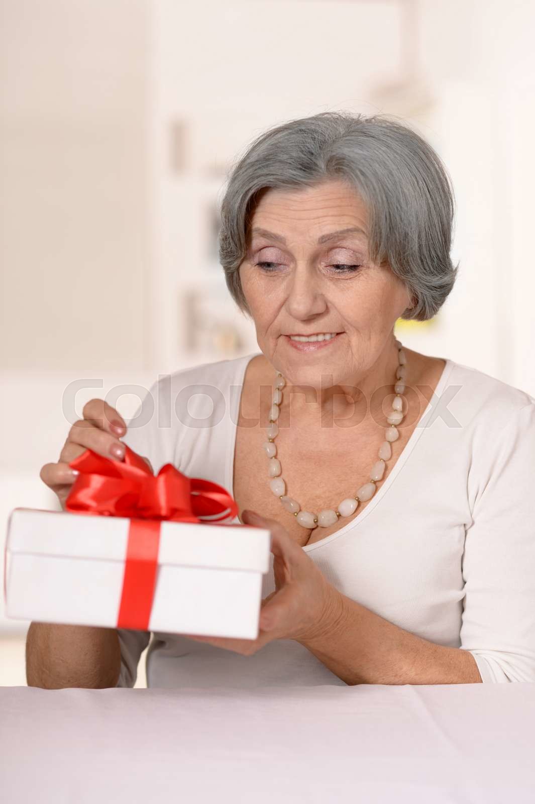 Older woman with gift | Stock image | Colourbox