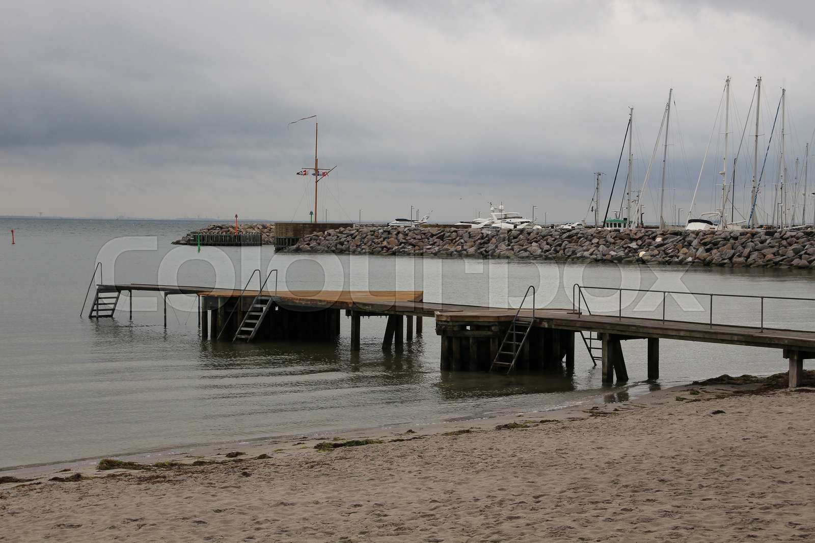 The harbour and a small beach with landing-stage and staircases in the ...