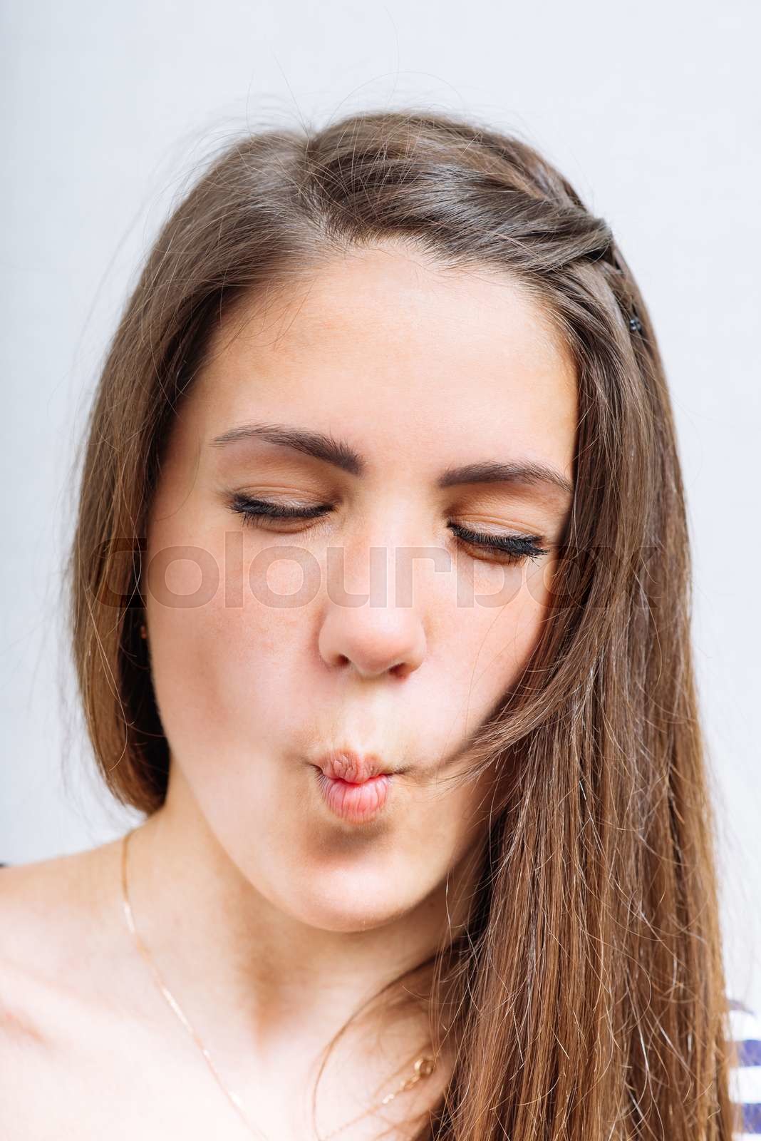Young woman squeezing cheeks | Stock image | Colourbox