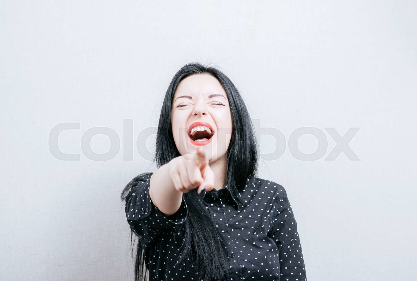 Woman laughing and pointing at someone | Stock image | Colourbox