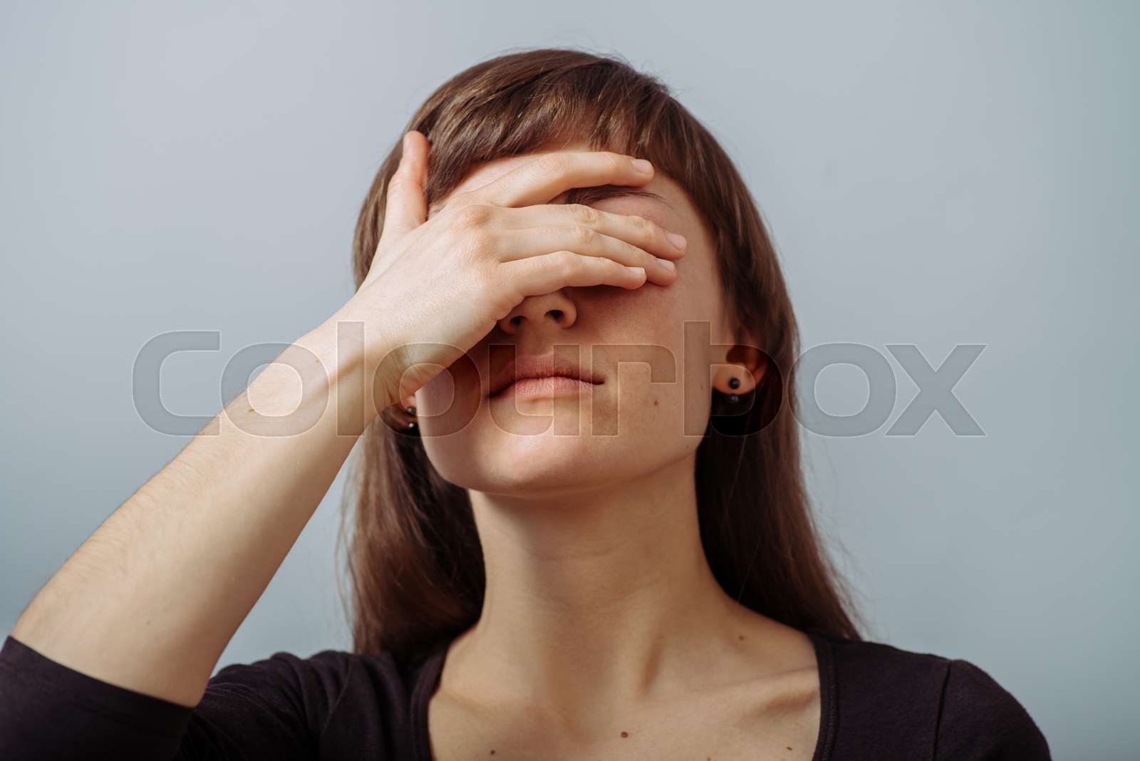 girl covers her face with his hand | Stock image | Colourbox