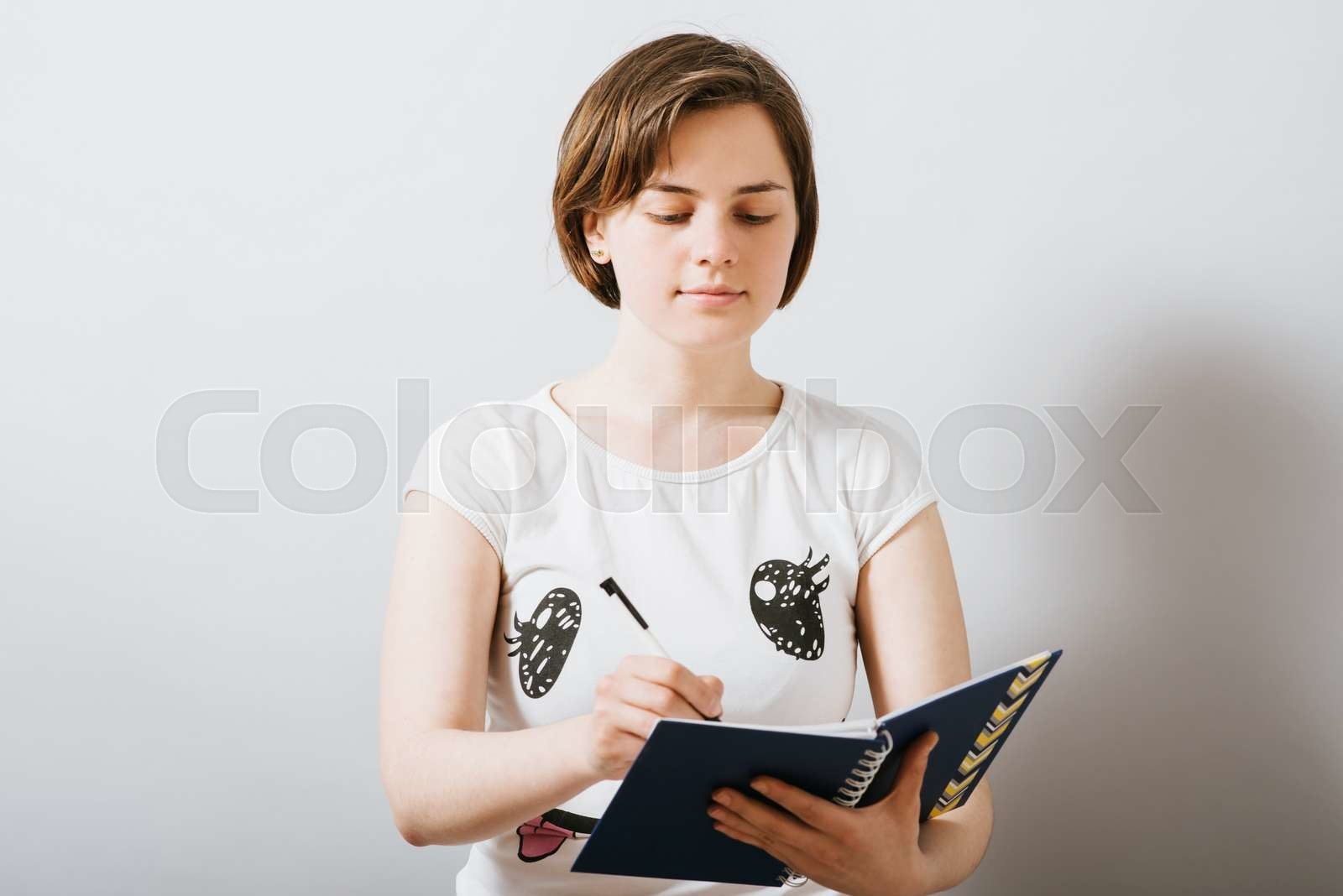 girl writing in a notebook | Stock image | Colourbox