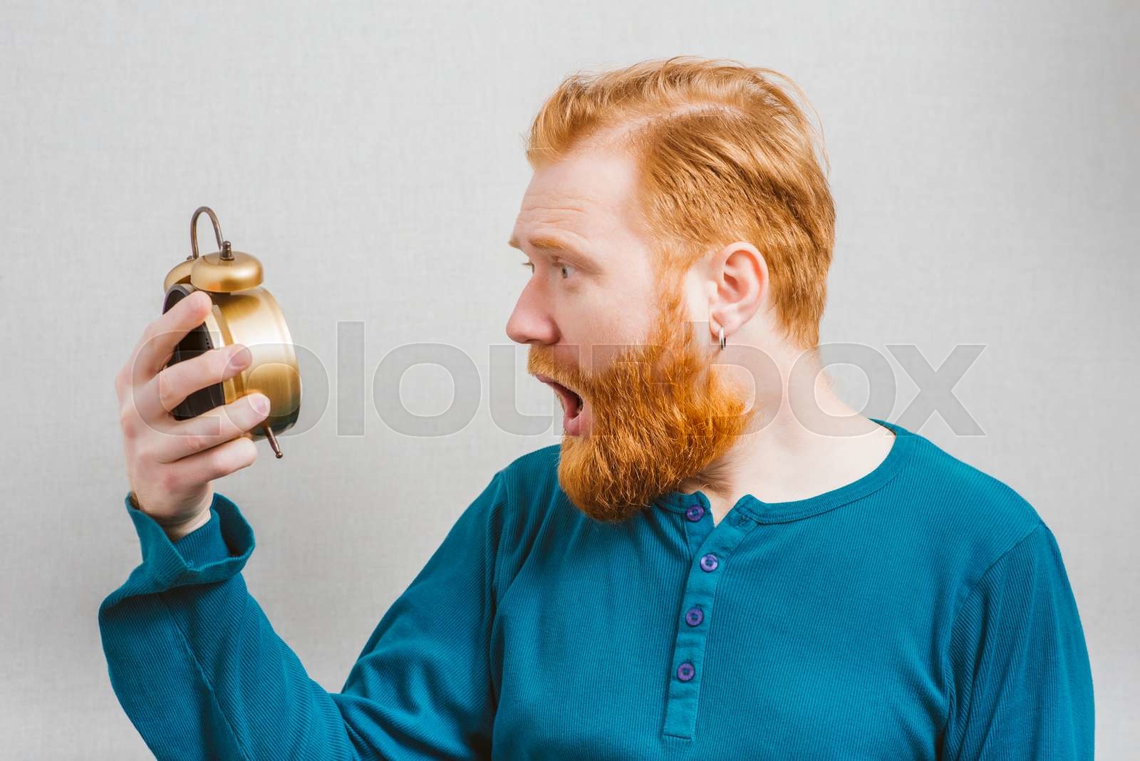 Yelling man with alarm clock in hand | Stock image | Colourbox