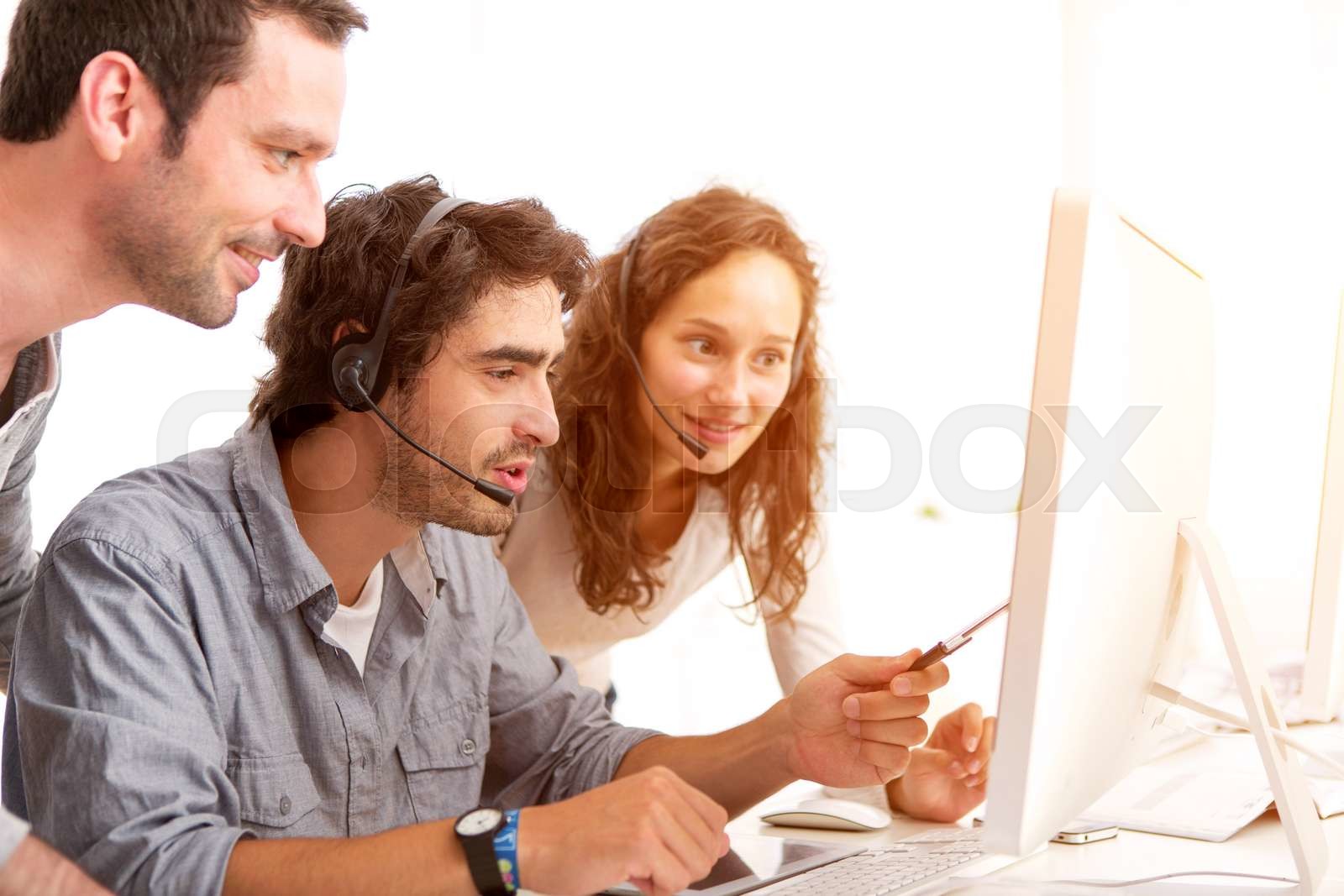 Group of people working around a computer | Stock image | Colourbox