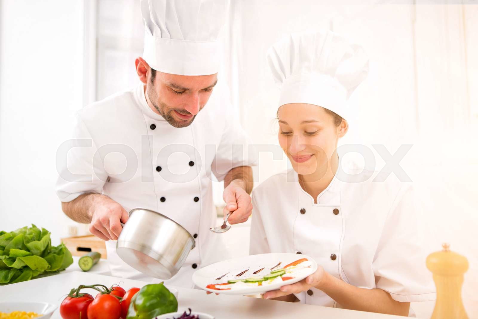 Young attractives professionals chefs cooking together | Stock image ...