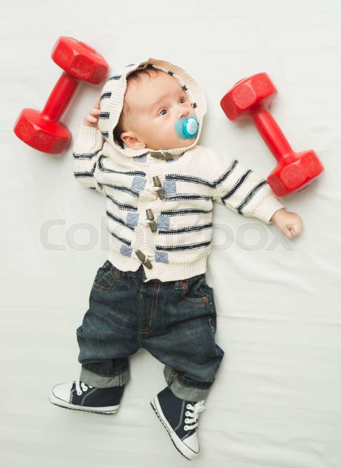 Toned photo of baby boy lifting heavy dumbbells | Stock image | Colourbox