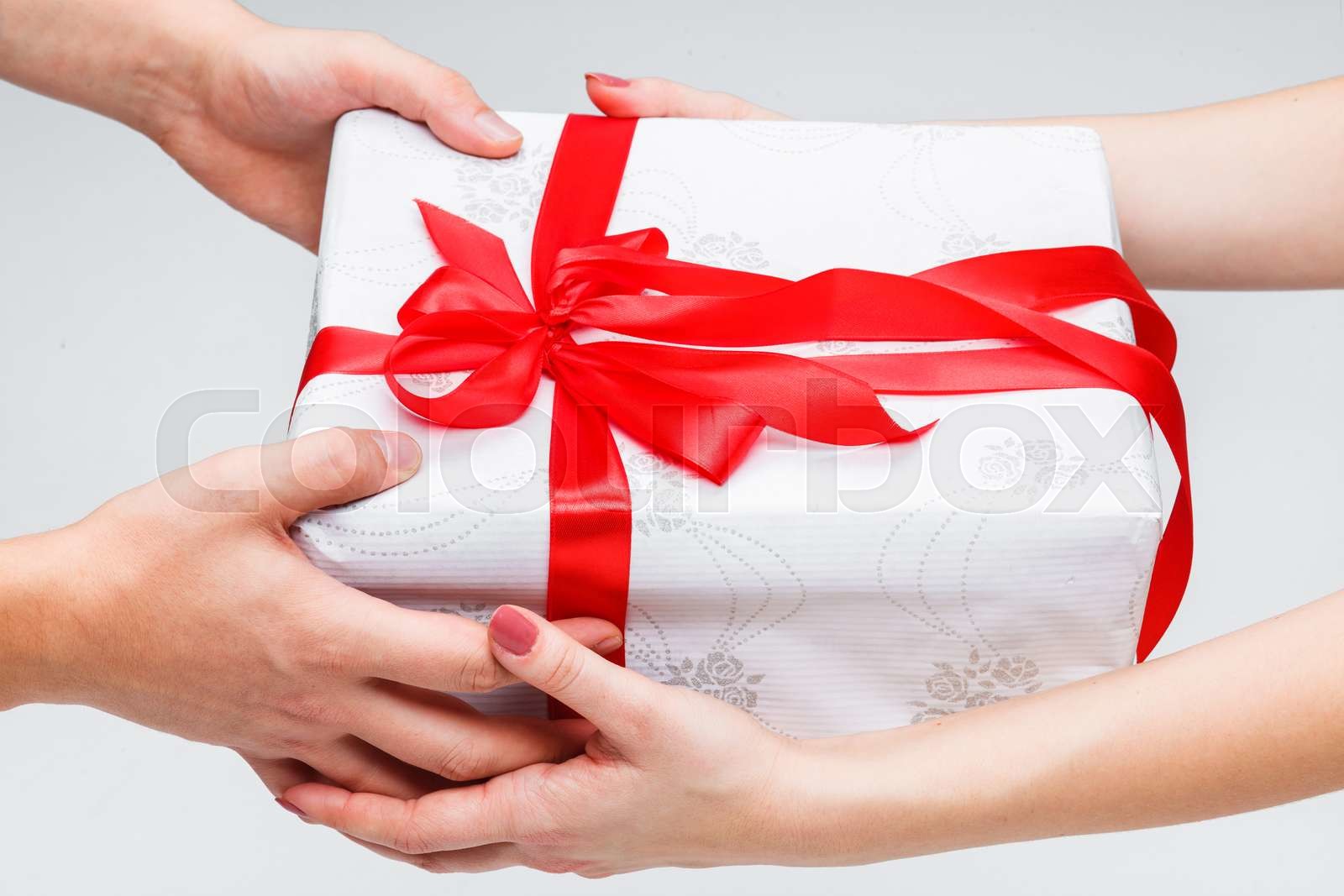 Hands giving and receiving a present | Stock image | Colourbox