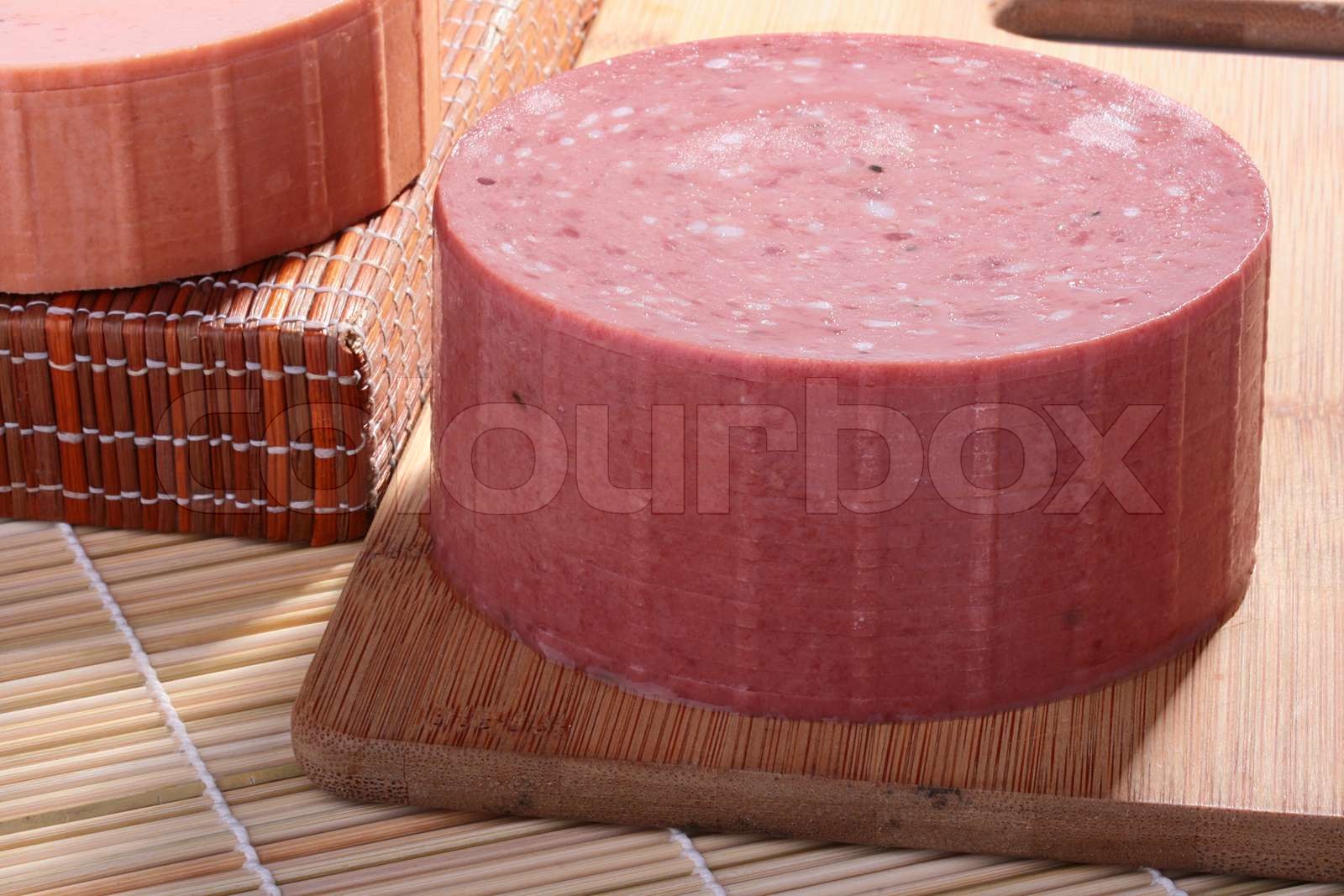 Wurst von der runden Form mit kleinen Scheiben von Fett auf eine Küche ...