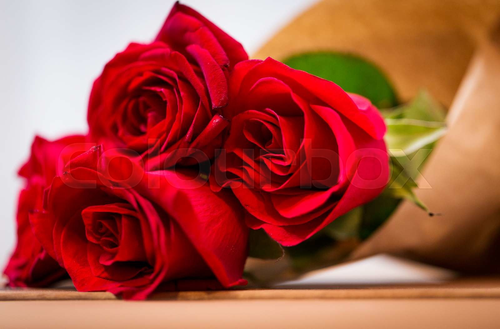 close up of red roses bunch wrapped into paper | Stock image | Colourbox