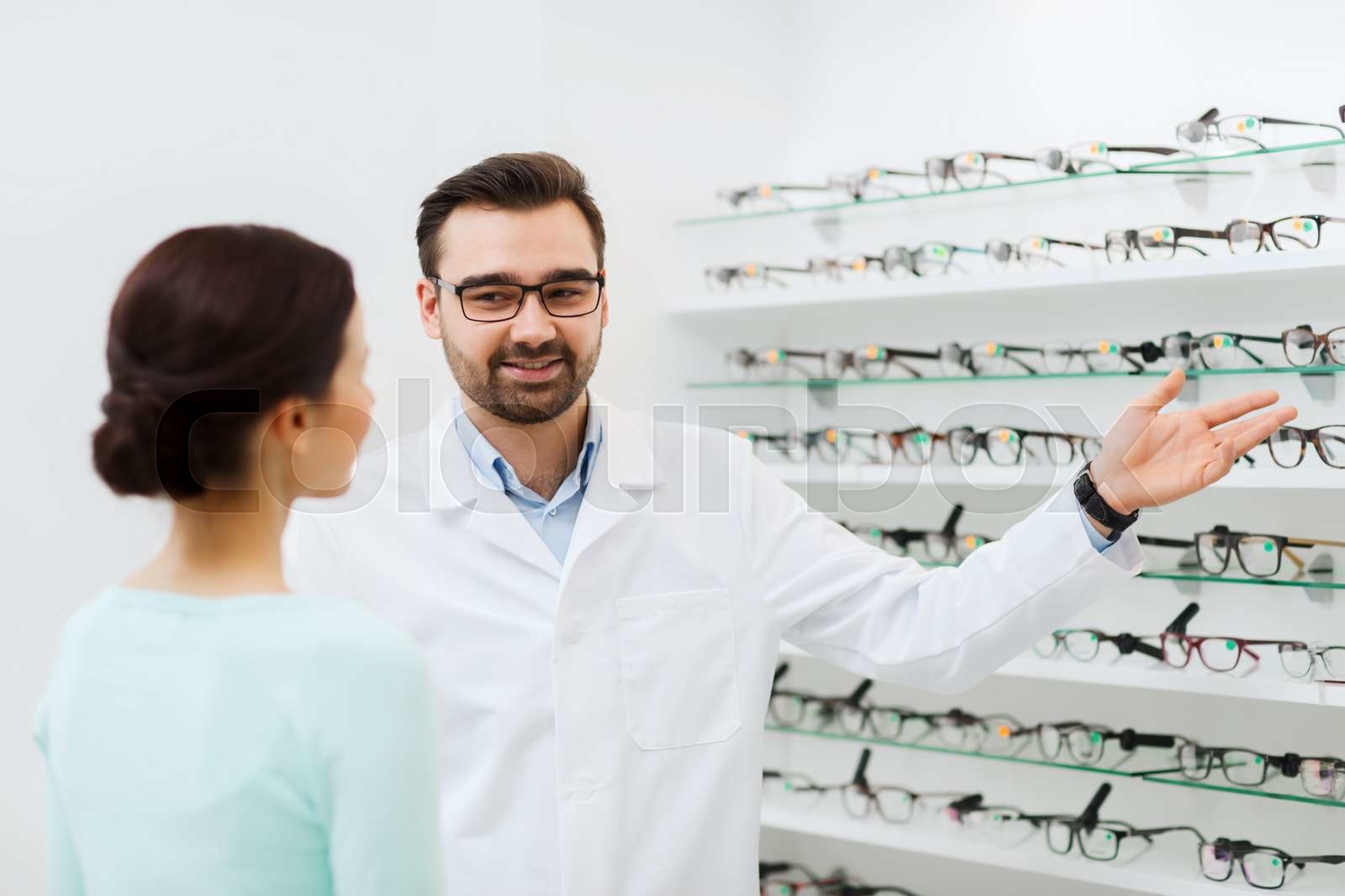 woman and optician showing glasses at optics store | Stock image ...