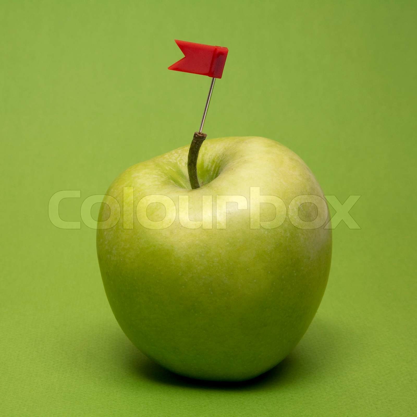 Green fresh apple marked with a small red flag | Stock image | Colourbox