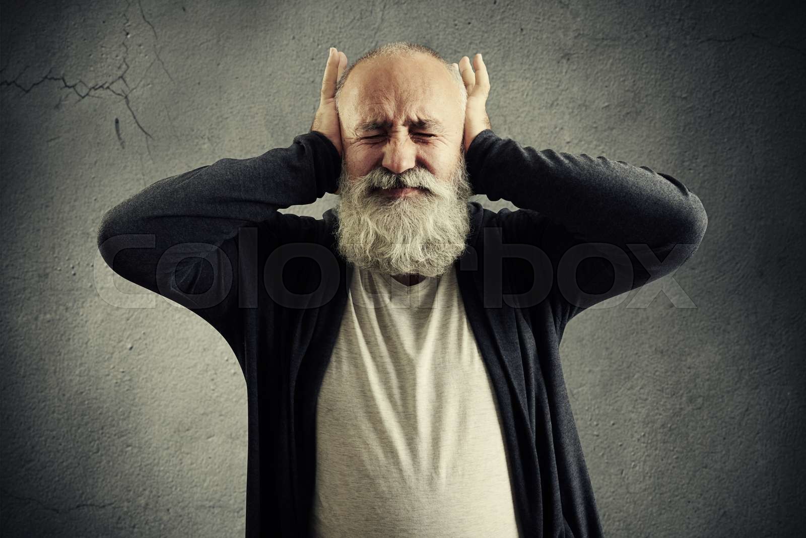man covering his ears and wincing | Stock image | Colourbox