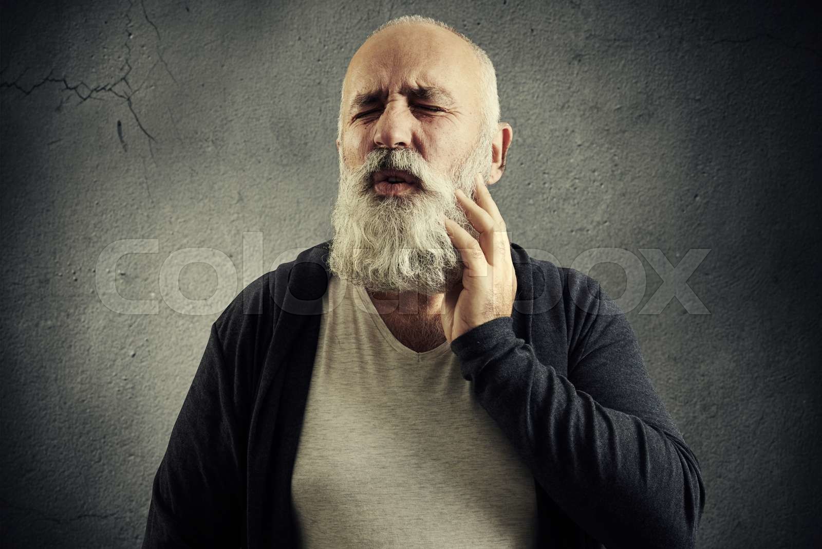 winced senior man over dark | Stock image | Colourbox