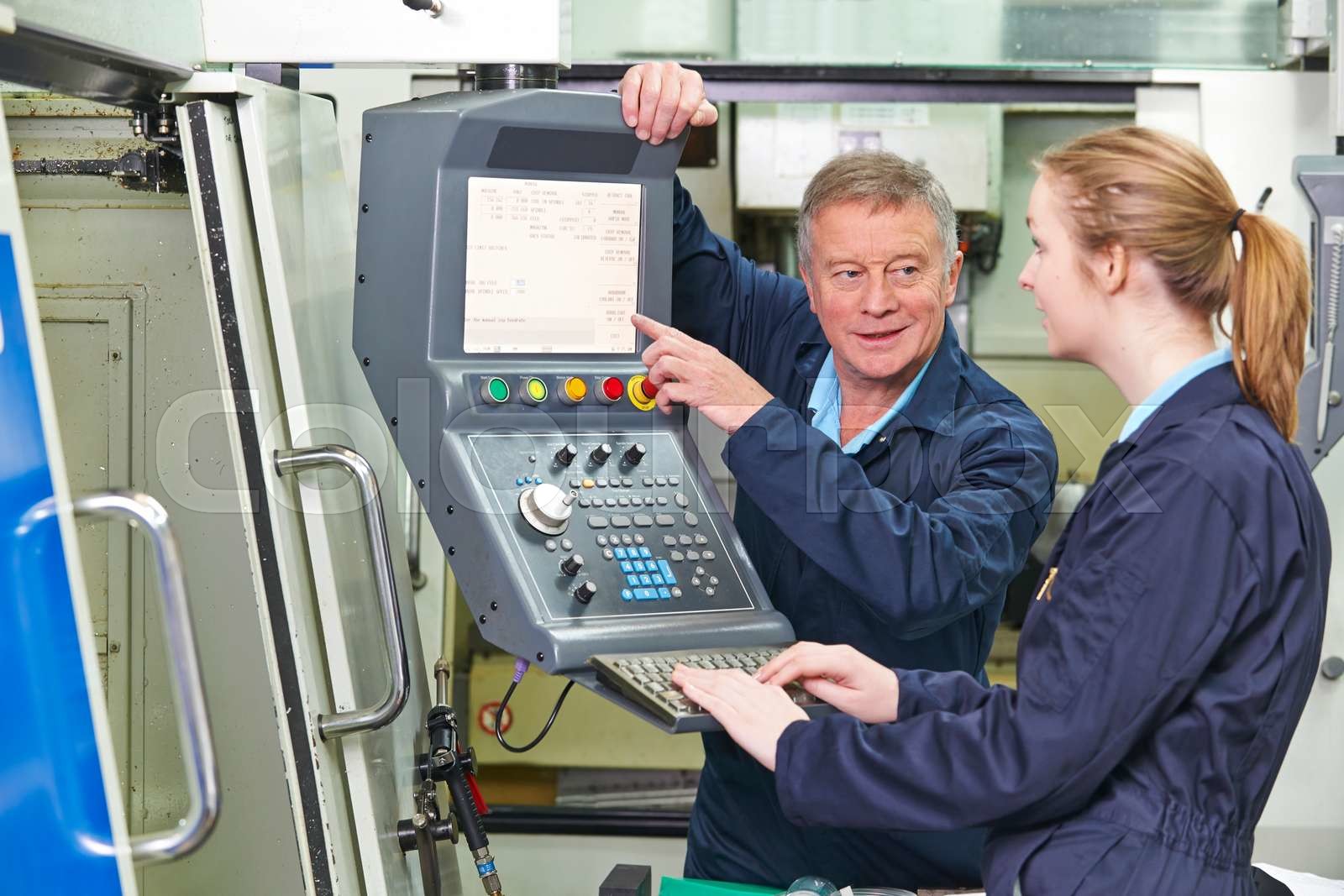 Engineer Showing Apprentice How to Use Computerized Cutting Machine ...