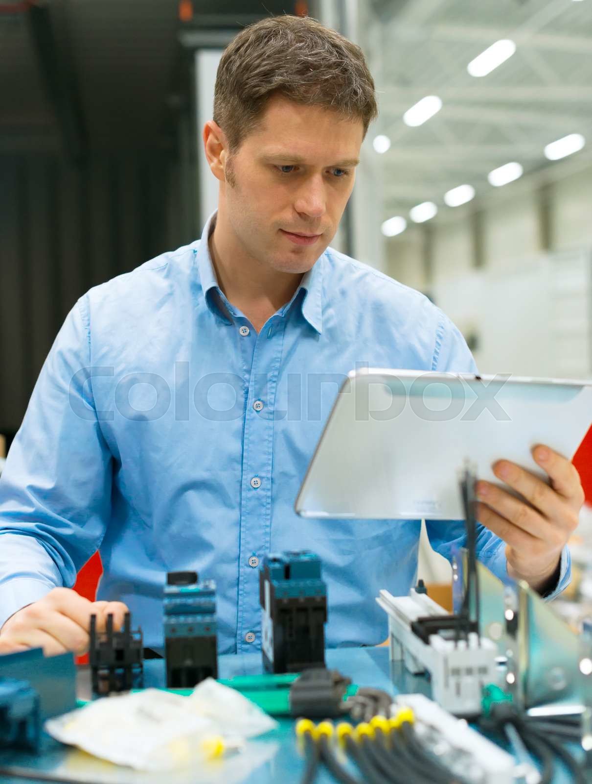 Handsome worker assembling electronic components at the factory ...