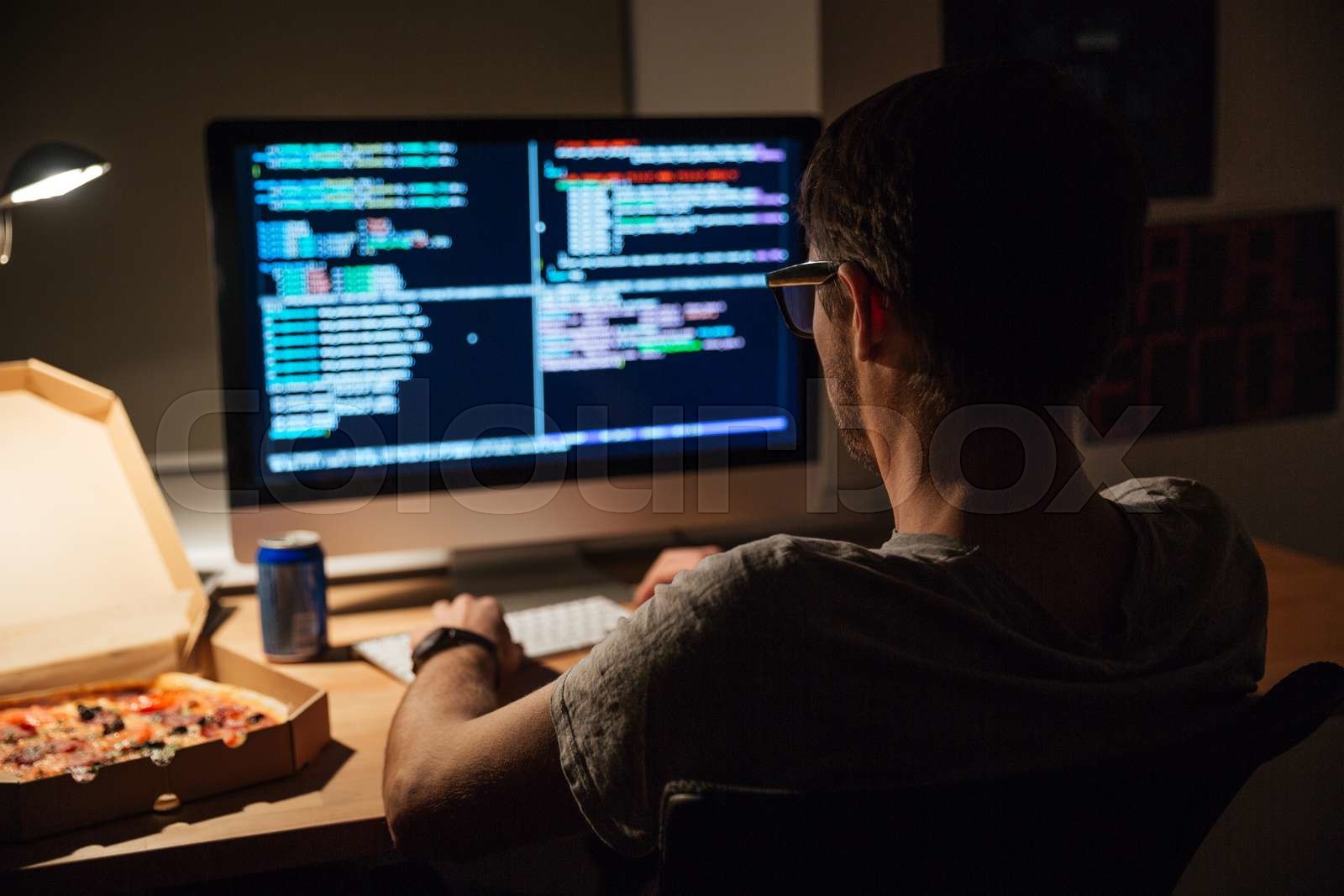 Back View Of Focused Programmer Writing Code And Eating Pizza | Stock