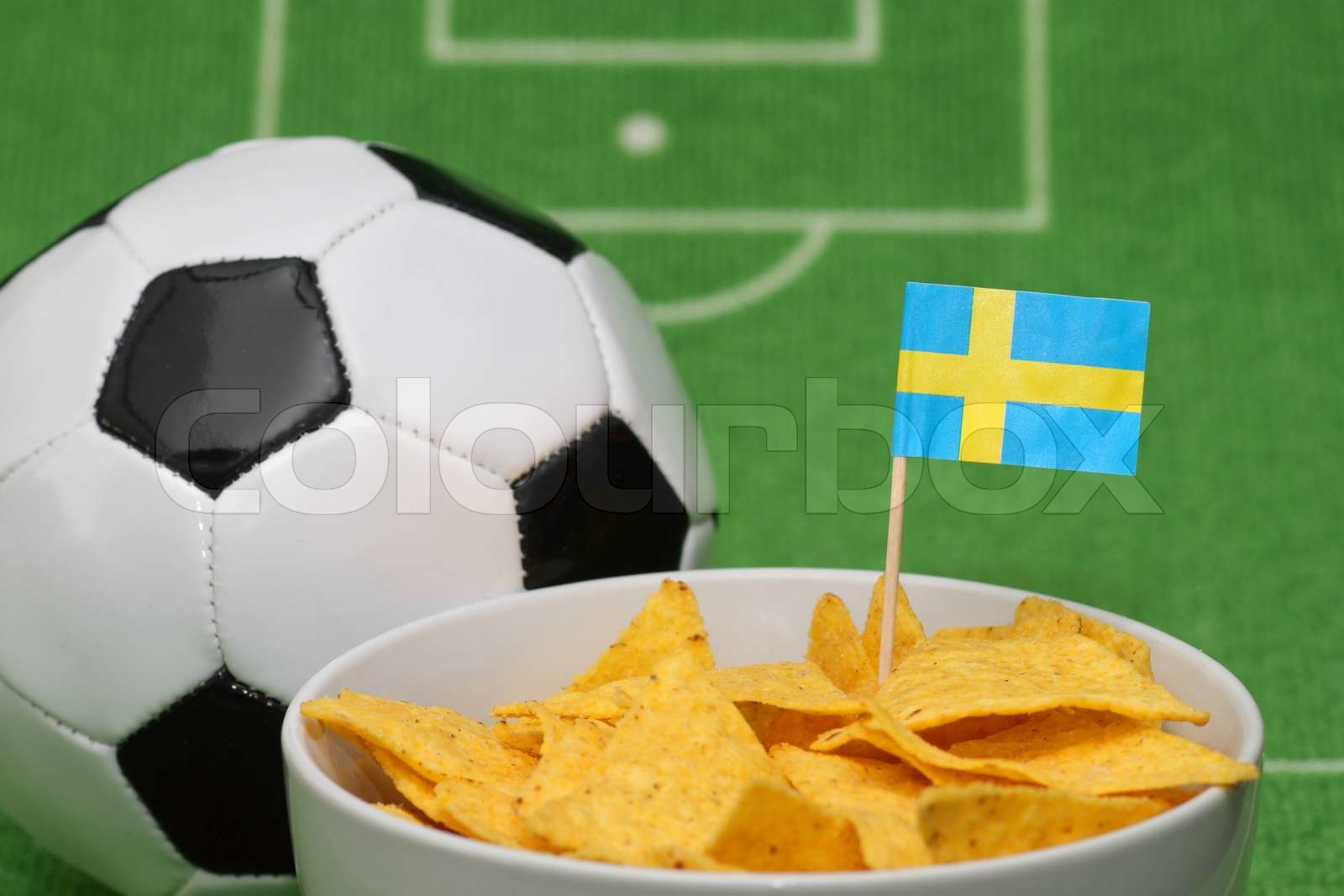 Fodbold med sprøde snacks i en skål på grøn baggrund | Stock foto ...
