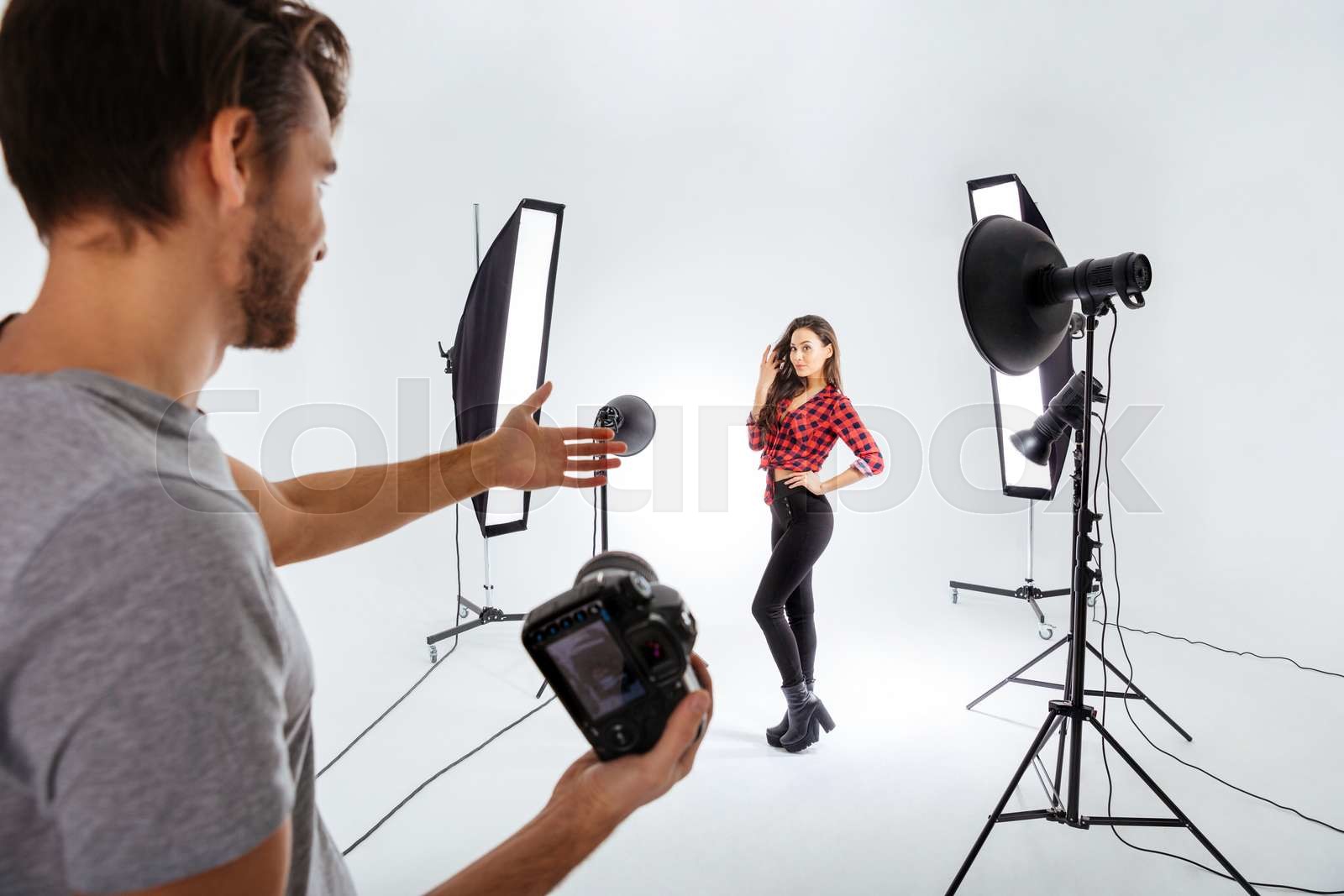 Photographer shooting model in studio | Stock image | Colourbox