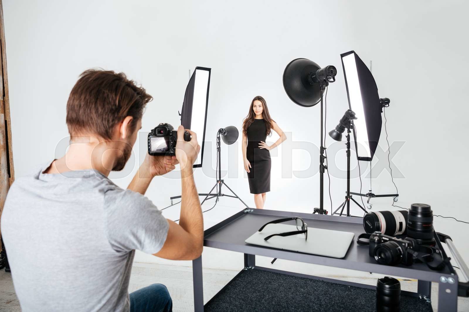 Man shooting female model in studio | Stock image | Colourbox