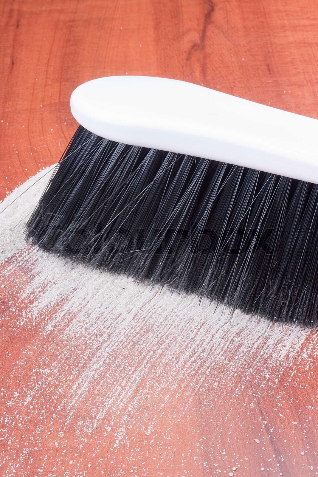 House cleaning, on a floor small sand simulating dust is scattered ...