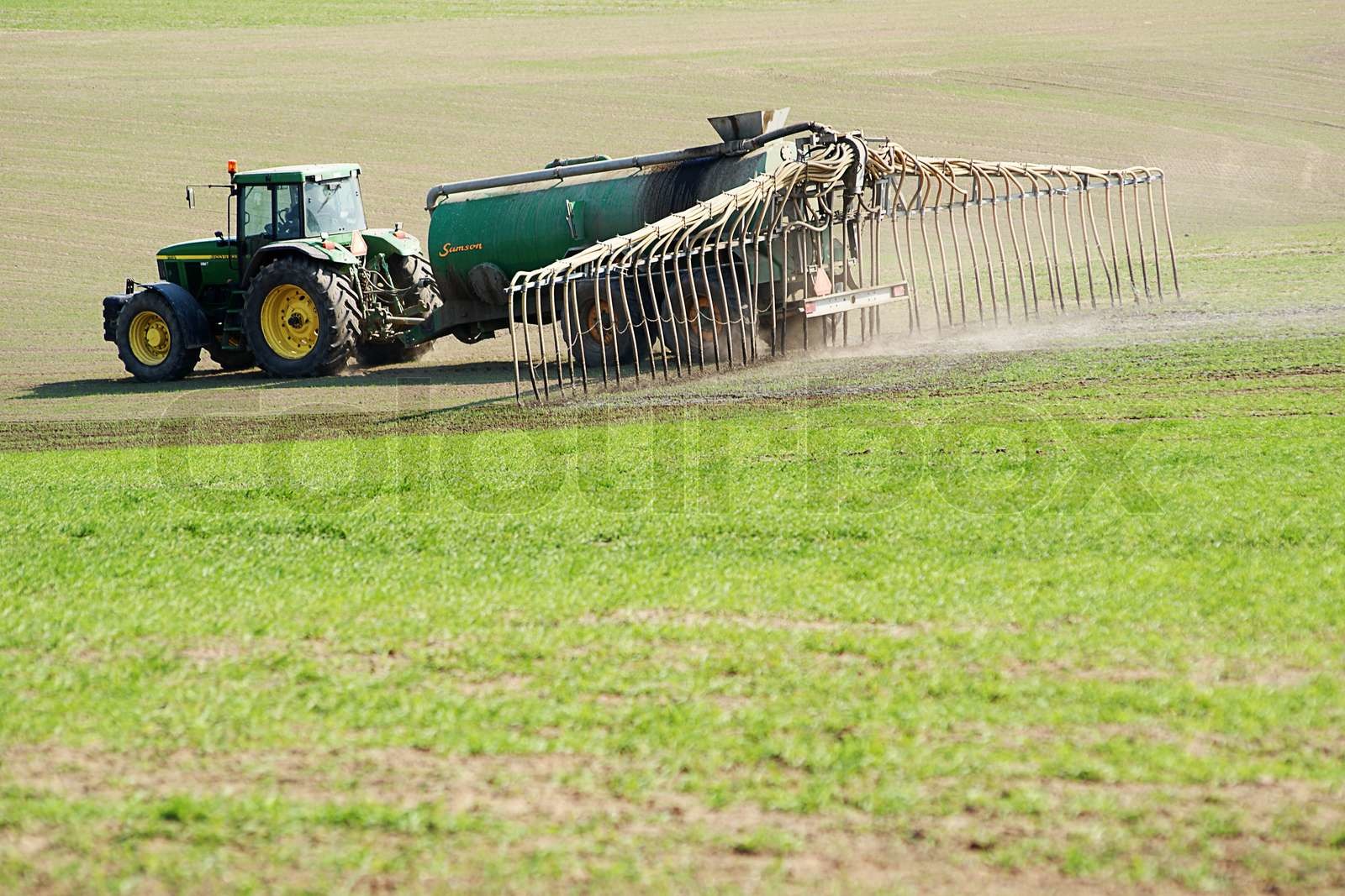 Manure tractor. Spreading manure in springtime. | Stock image | Colourbox