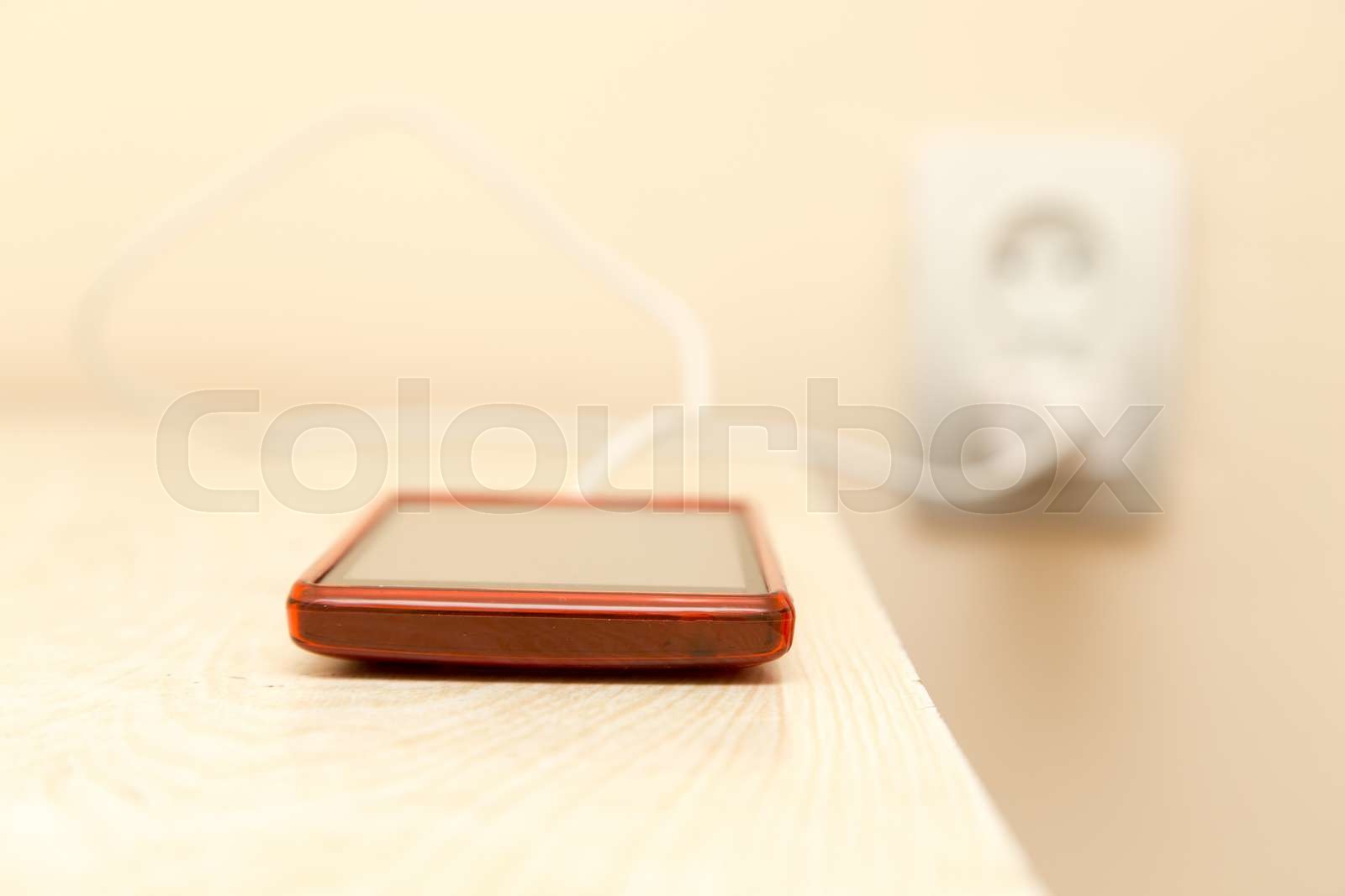 cell phone is being charged from the electrical outlet | Stock image ...