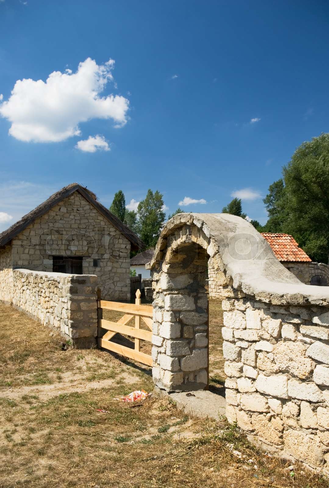 old stone fence with a gate built of limestone | Stock image | Colourbox
