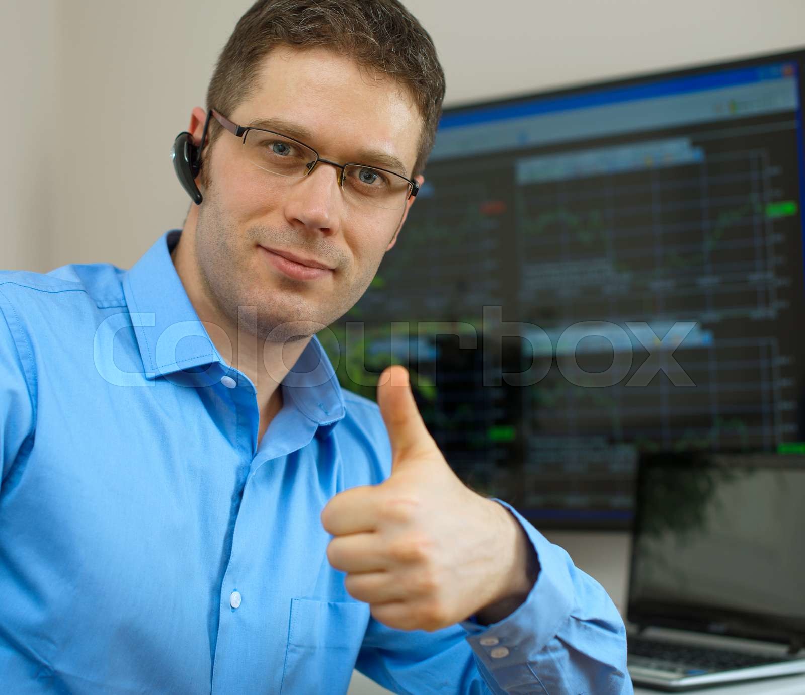 Handsome stock trader with thumbs up in front of computer. | Stock ...