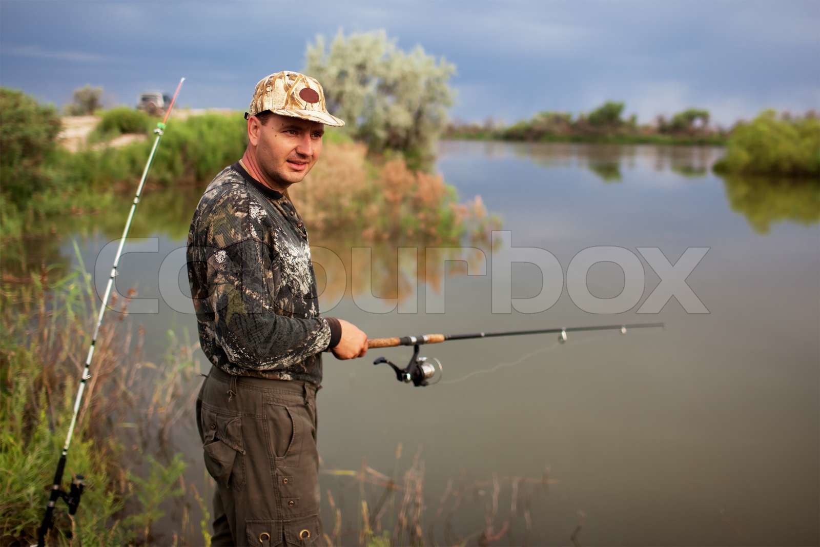 Fisherman with rod on river | Stock image | Colourbox