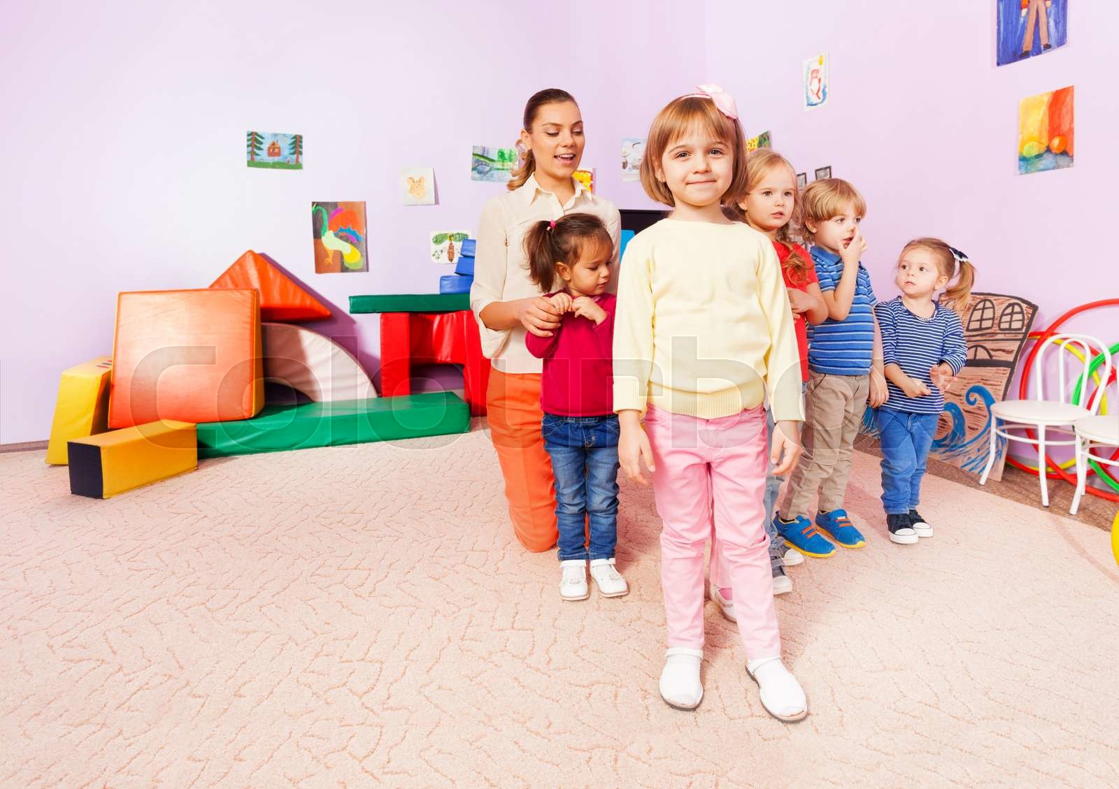Group of kids stand in kindergarten with teacher | Stock image | Colourbox