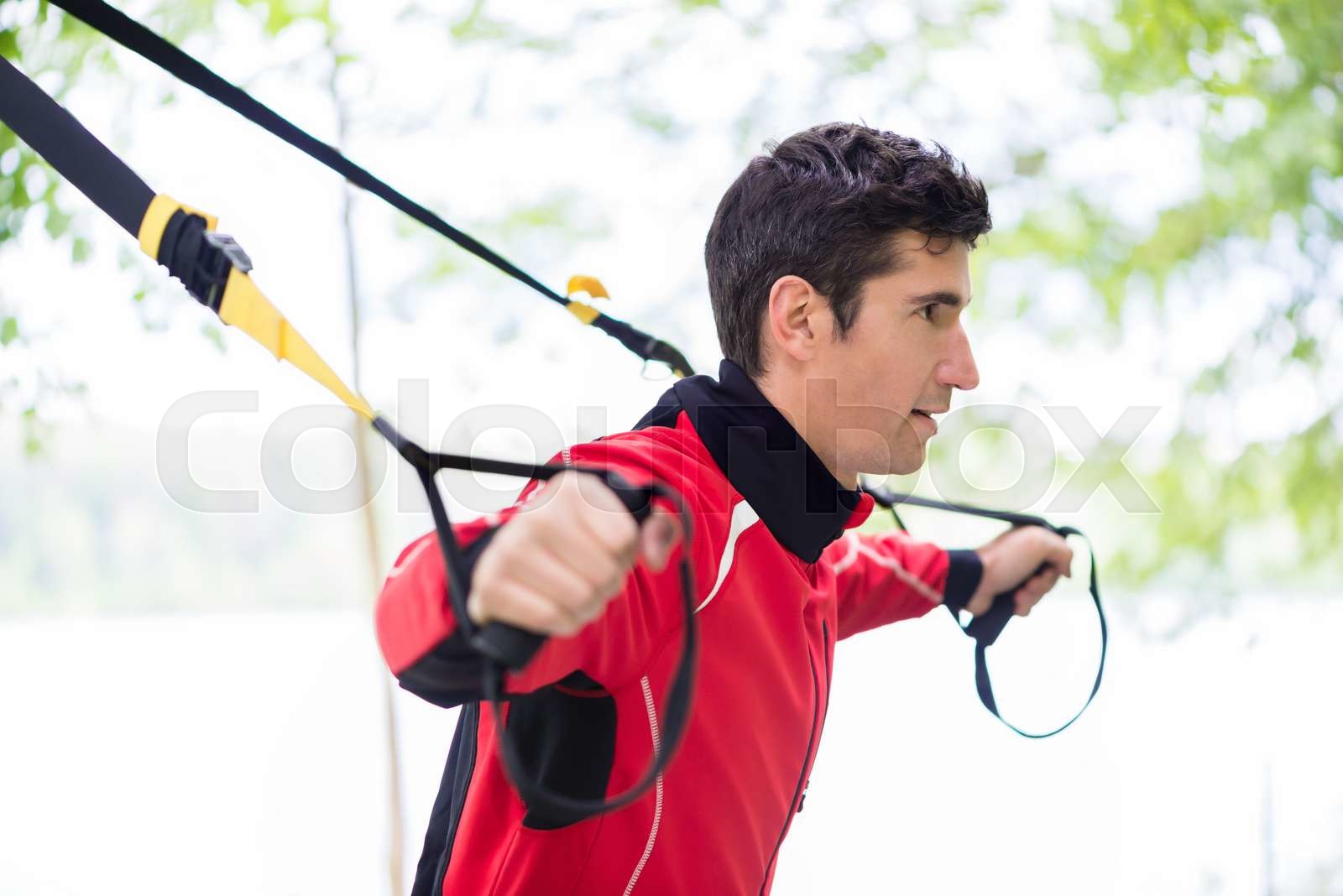 Man doing fitness sling training outdoors | Stock image | Colourbox