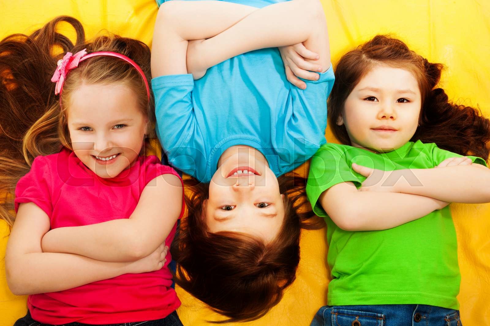 Little children laying together on the floor | Stock image | Colourbox