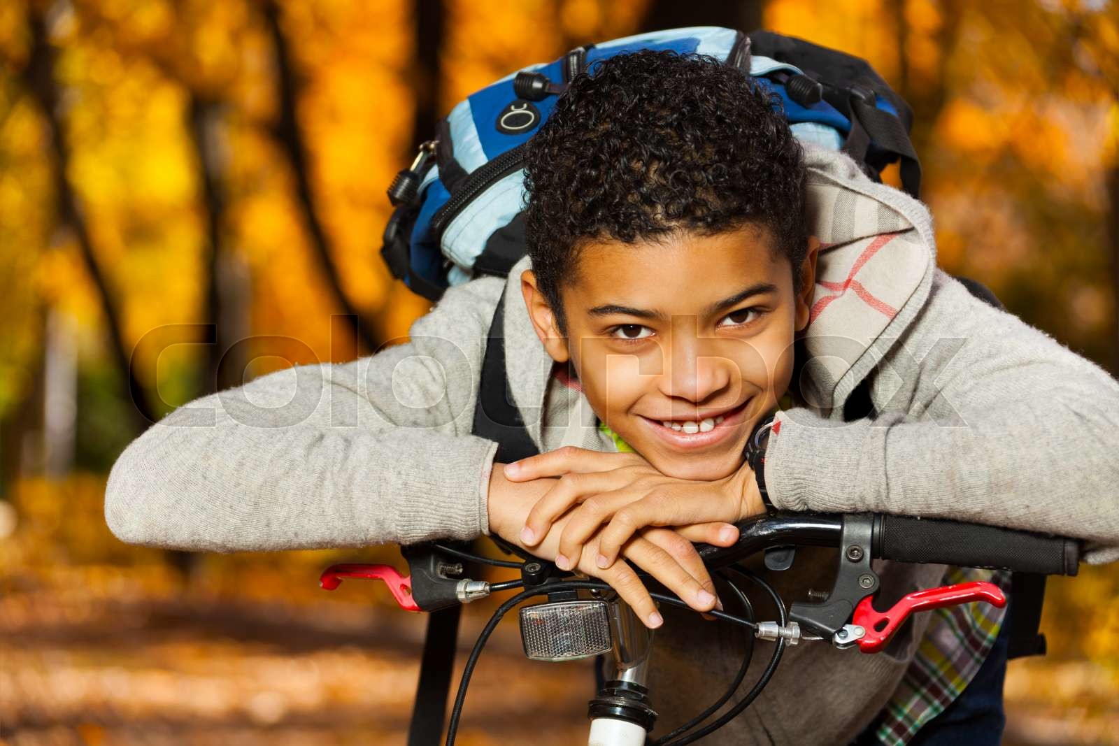 Boy smile laying on bike stern | Stock image | Colourbox