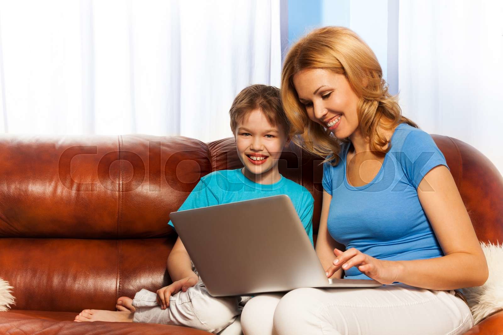 Happy mum and son with laptop on the sofa | Stock image | Colourbox