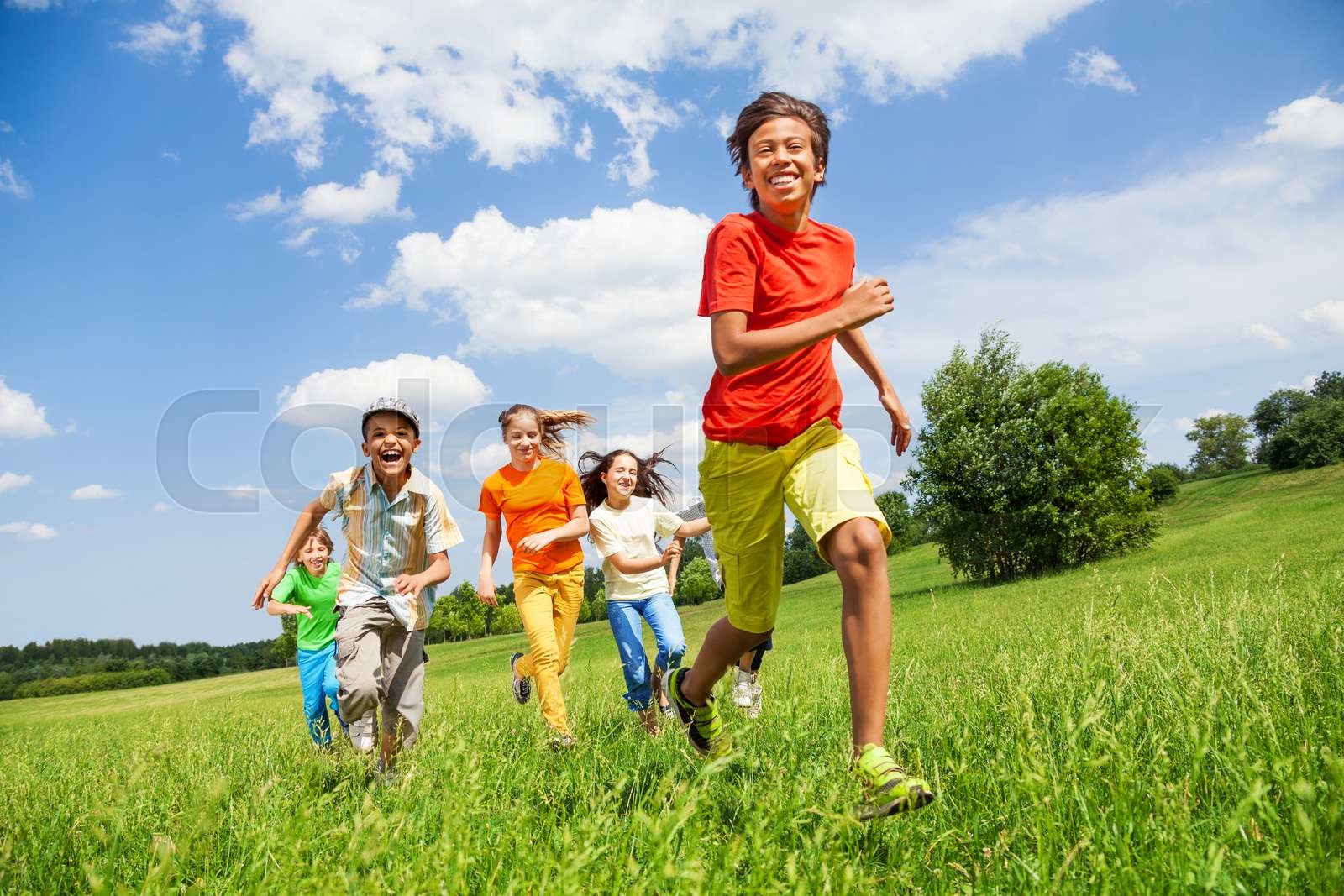 Happy children running together in the field | Stock image | Colourbox