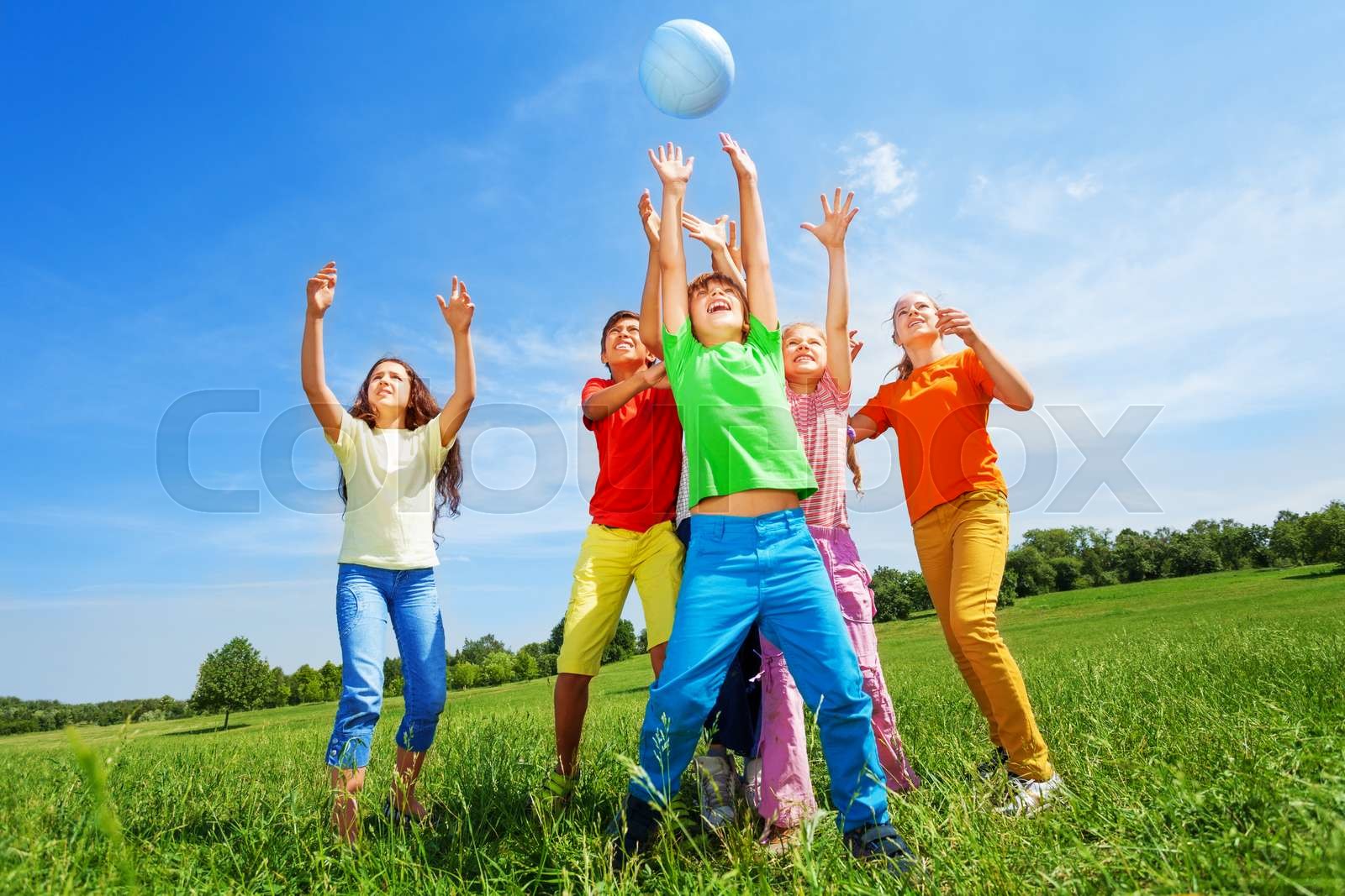 Happy kids catching ball in air outside | Stock image | Colourbox