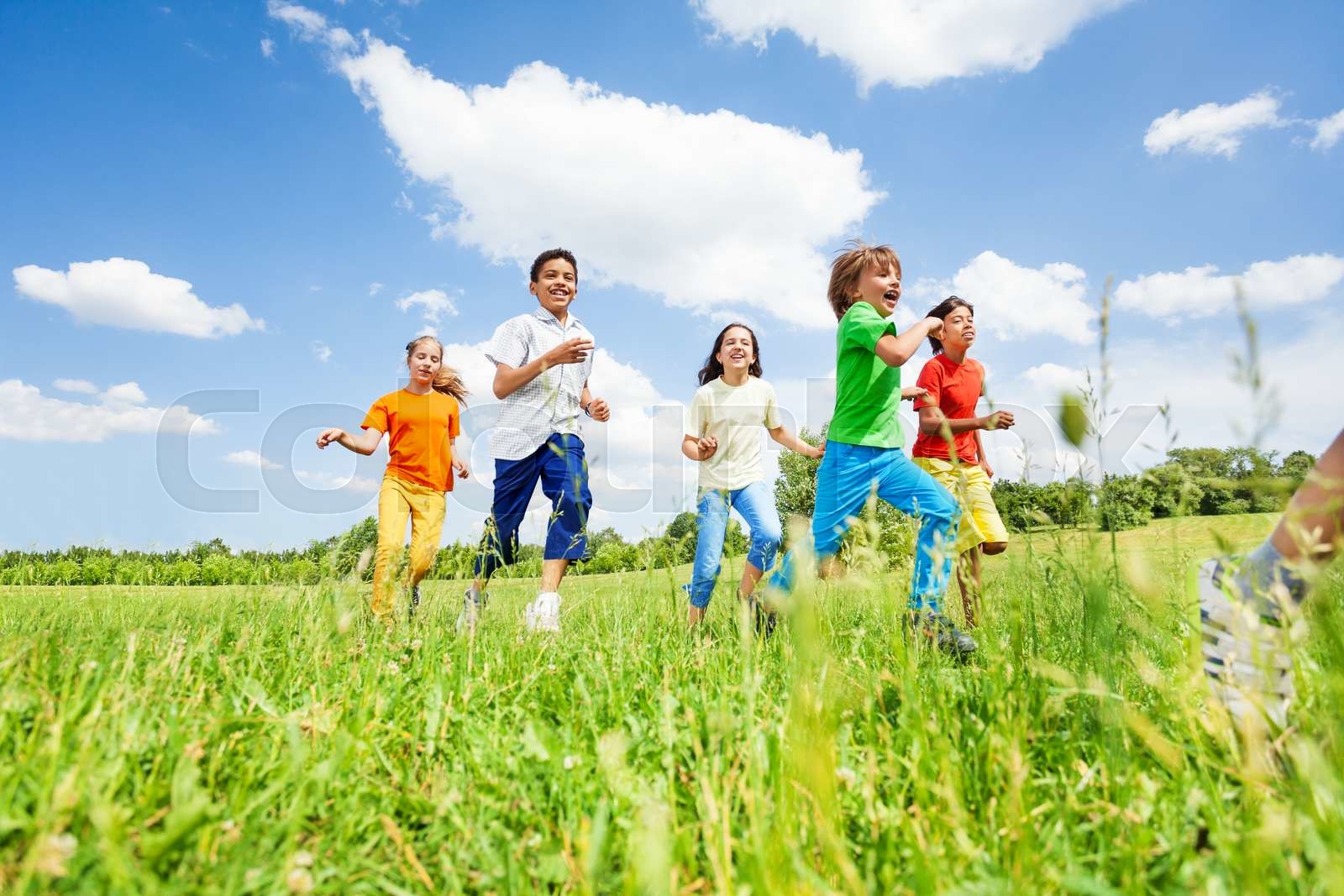 Positive kids playing and running in the field | Stock image | Colourbox