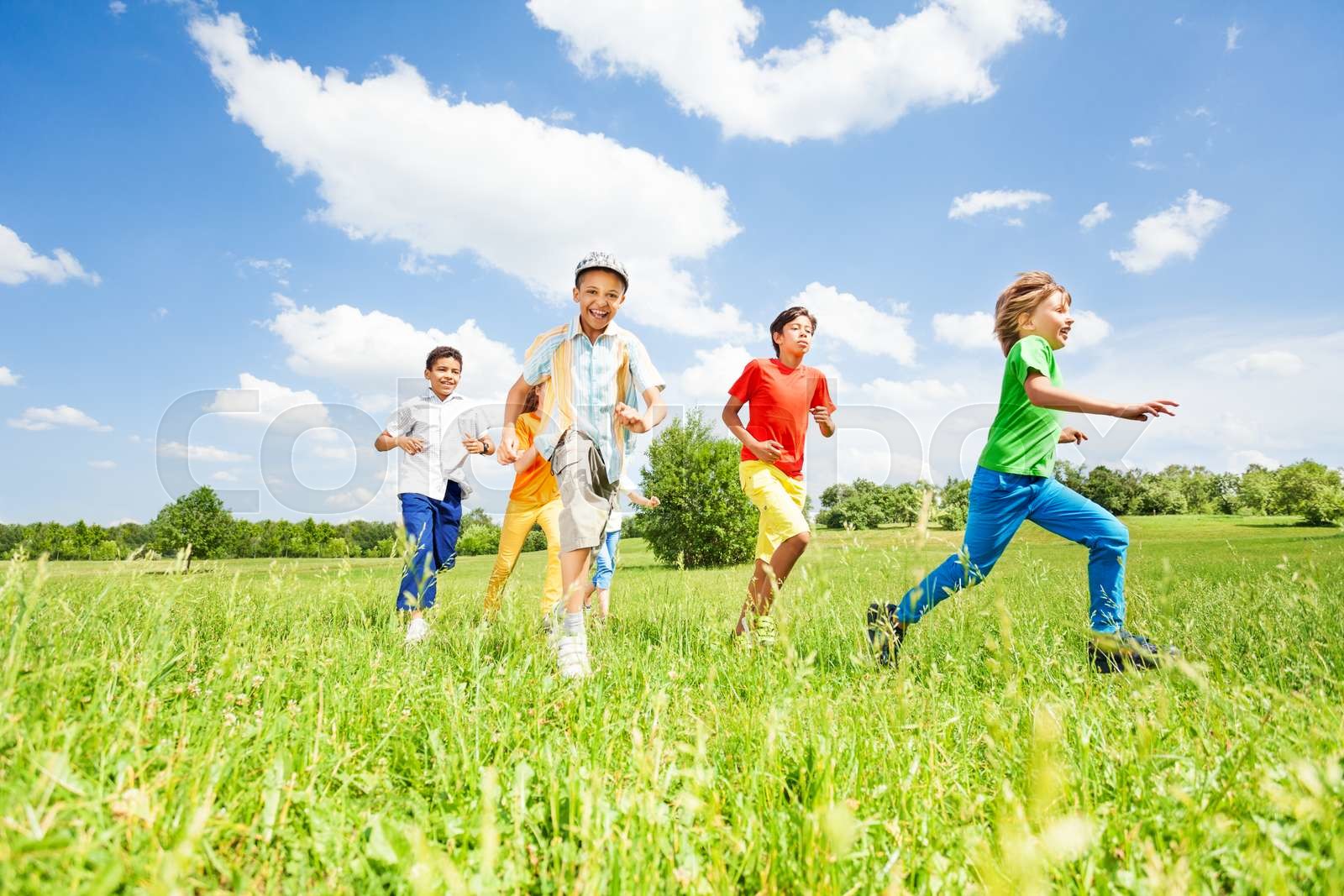Excited kids playing and running in the field | Stock image | Colourbox
