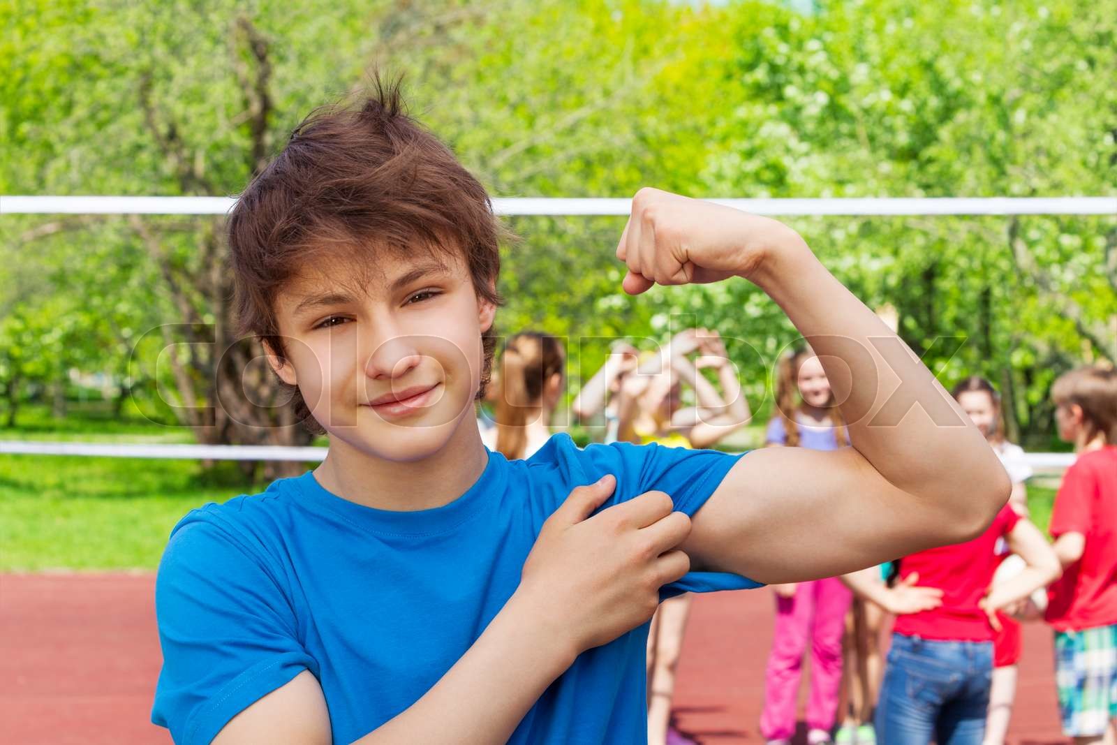 Teenager boy shows bicep muscles on the playground | Stock image ...
