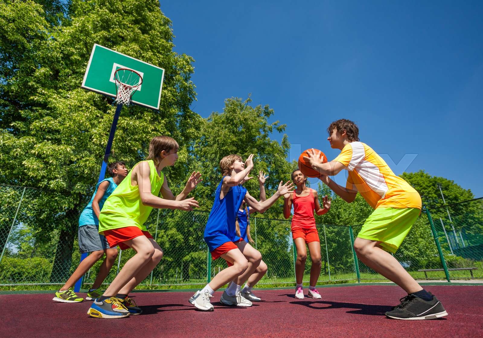 Teenage children playing basketball game together | Stock image | Colourbox