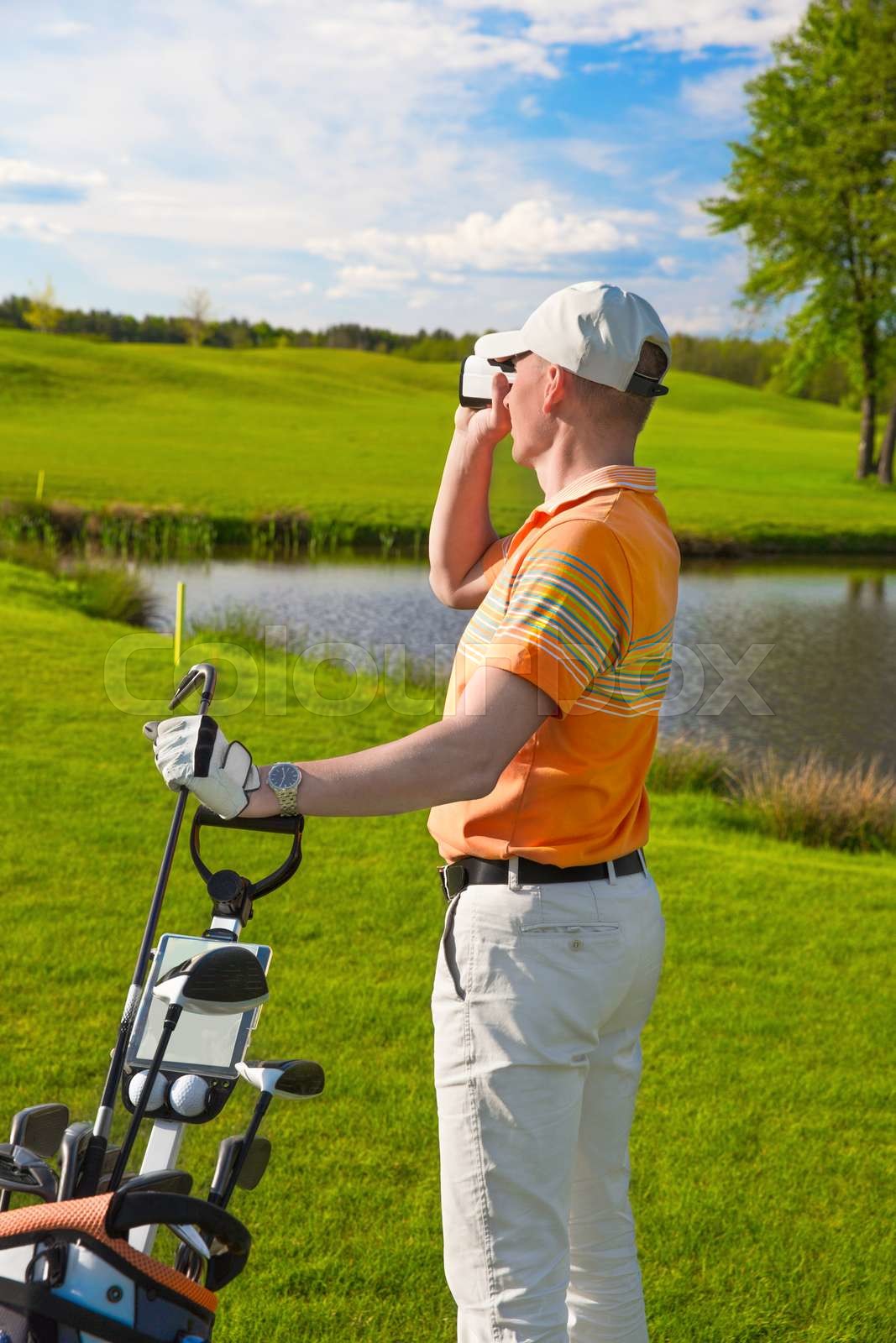 man golfer watching into rangefinder | Stock image | Colourbox