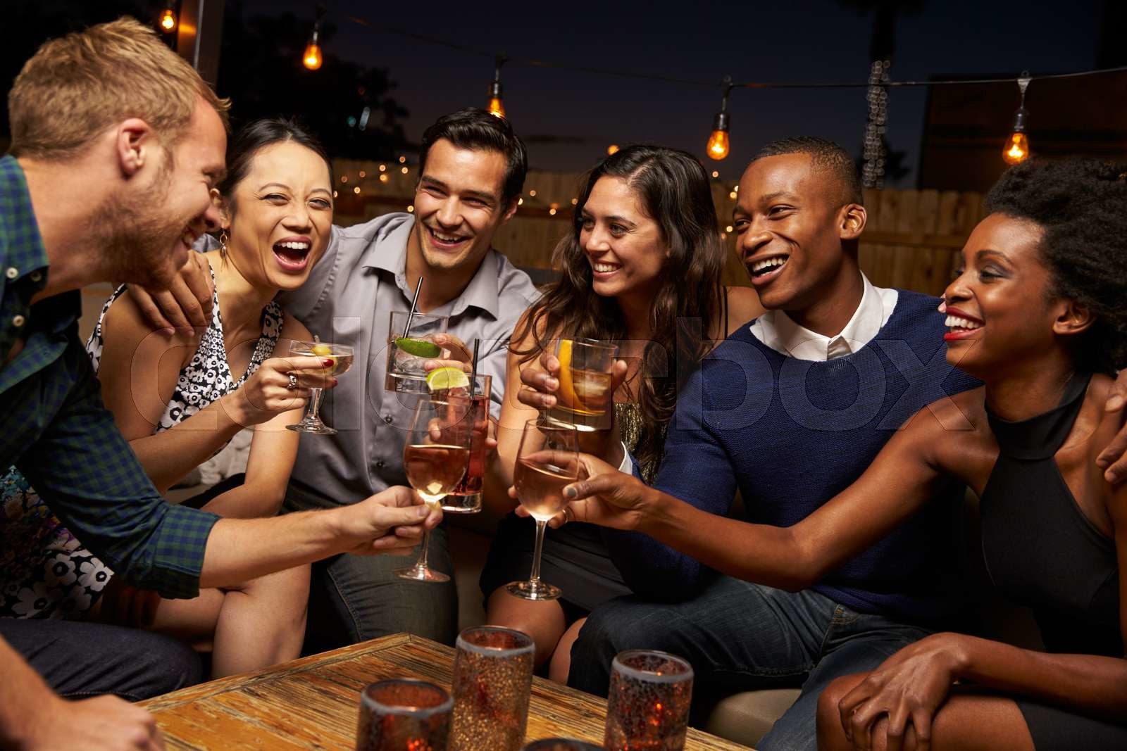 Group Of Friends Enjoying Night Out At Rooftop Bar | Stock image ...