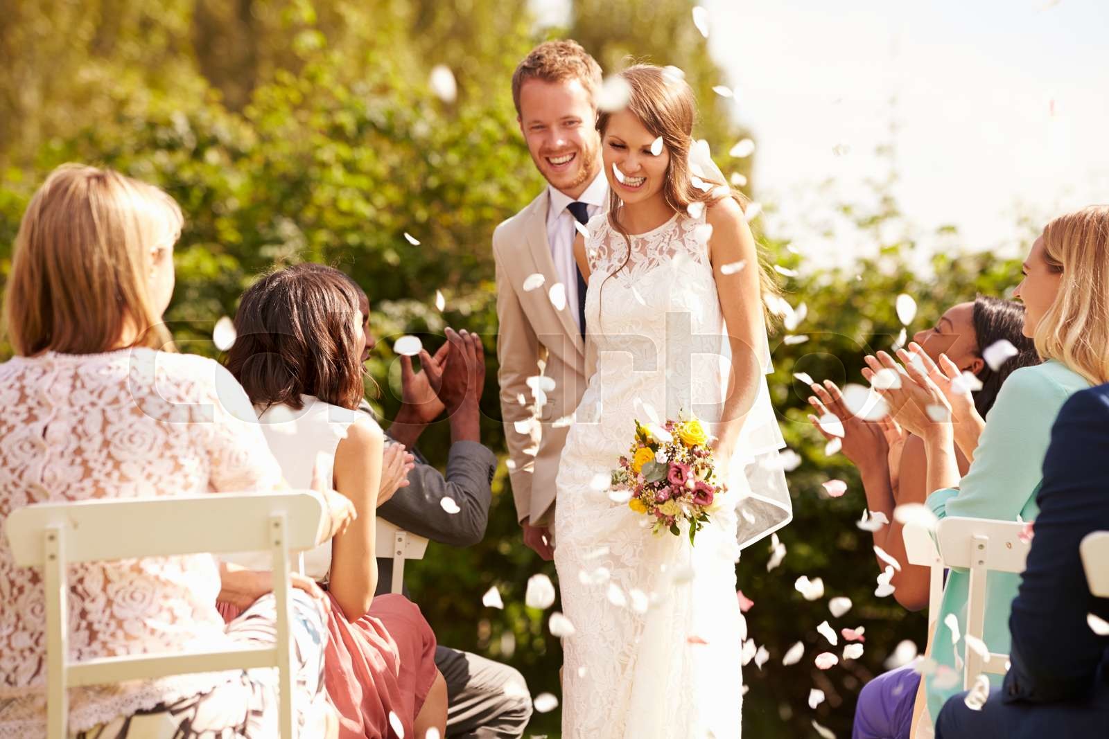 Guests Throwing Confetti Over Bride And Groom At Wedding | Stock image ...