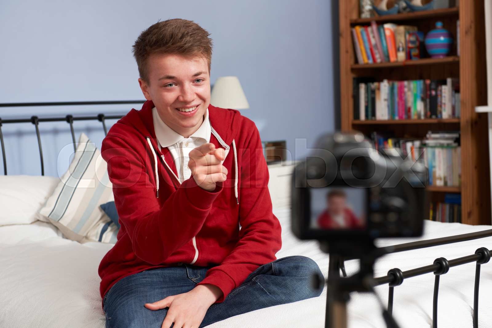 Teenage Boy Recording Video Of Himself In Bedroom | Stock image | Colourbox